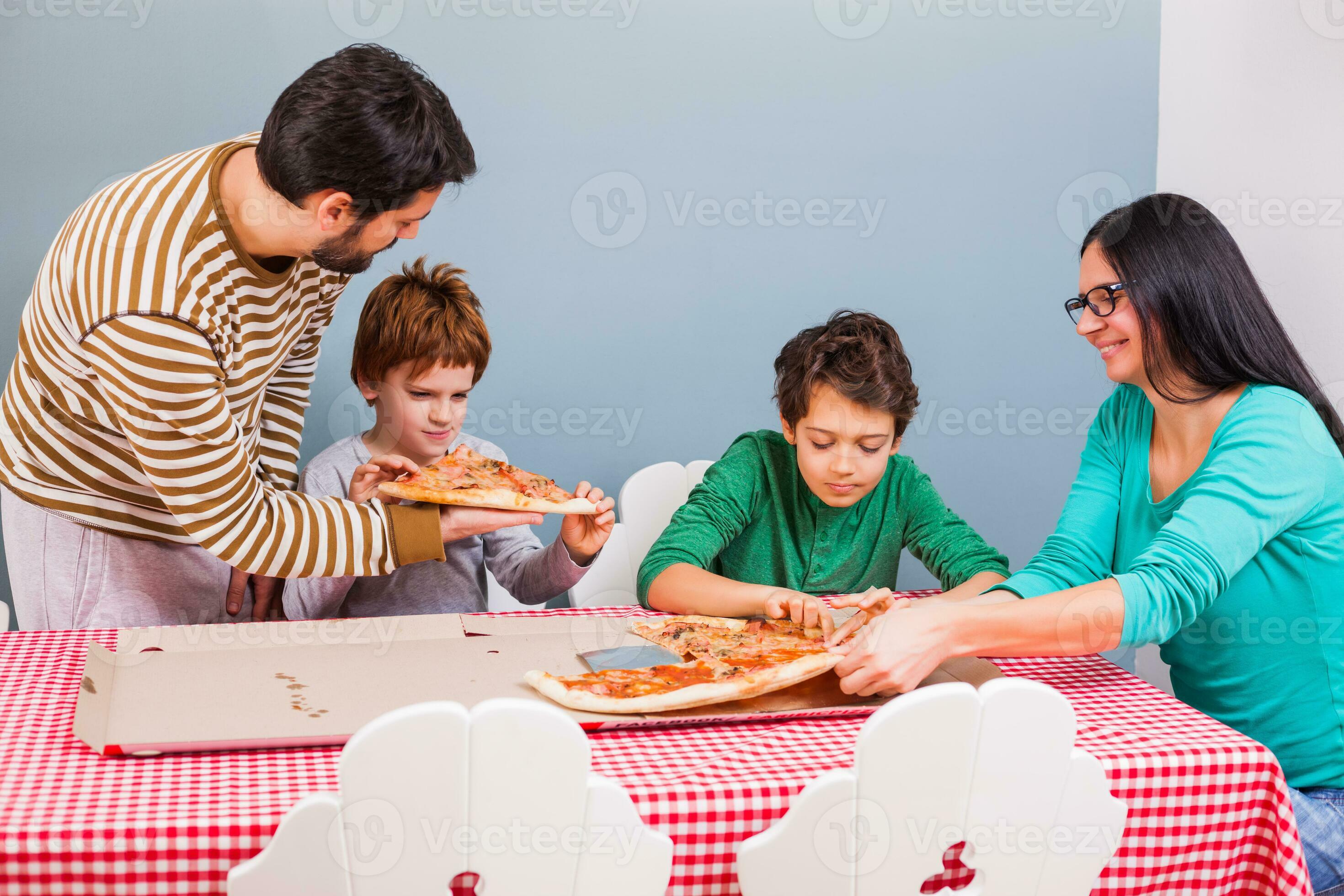 un familia comiendo Pizza 23921713 Foto de stock en Vecteezy