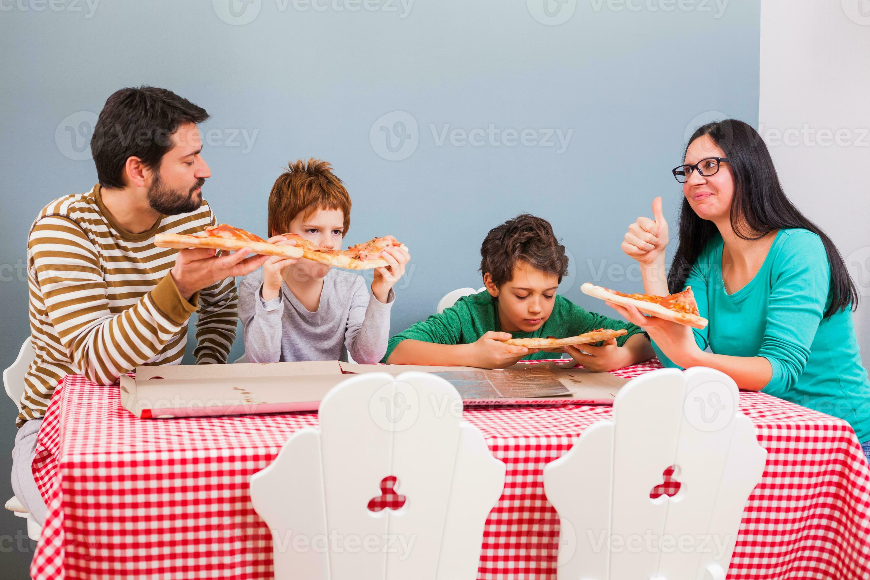 un familia comiendo Pizza 23922016 Foto de stock en Vecteezy