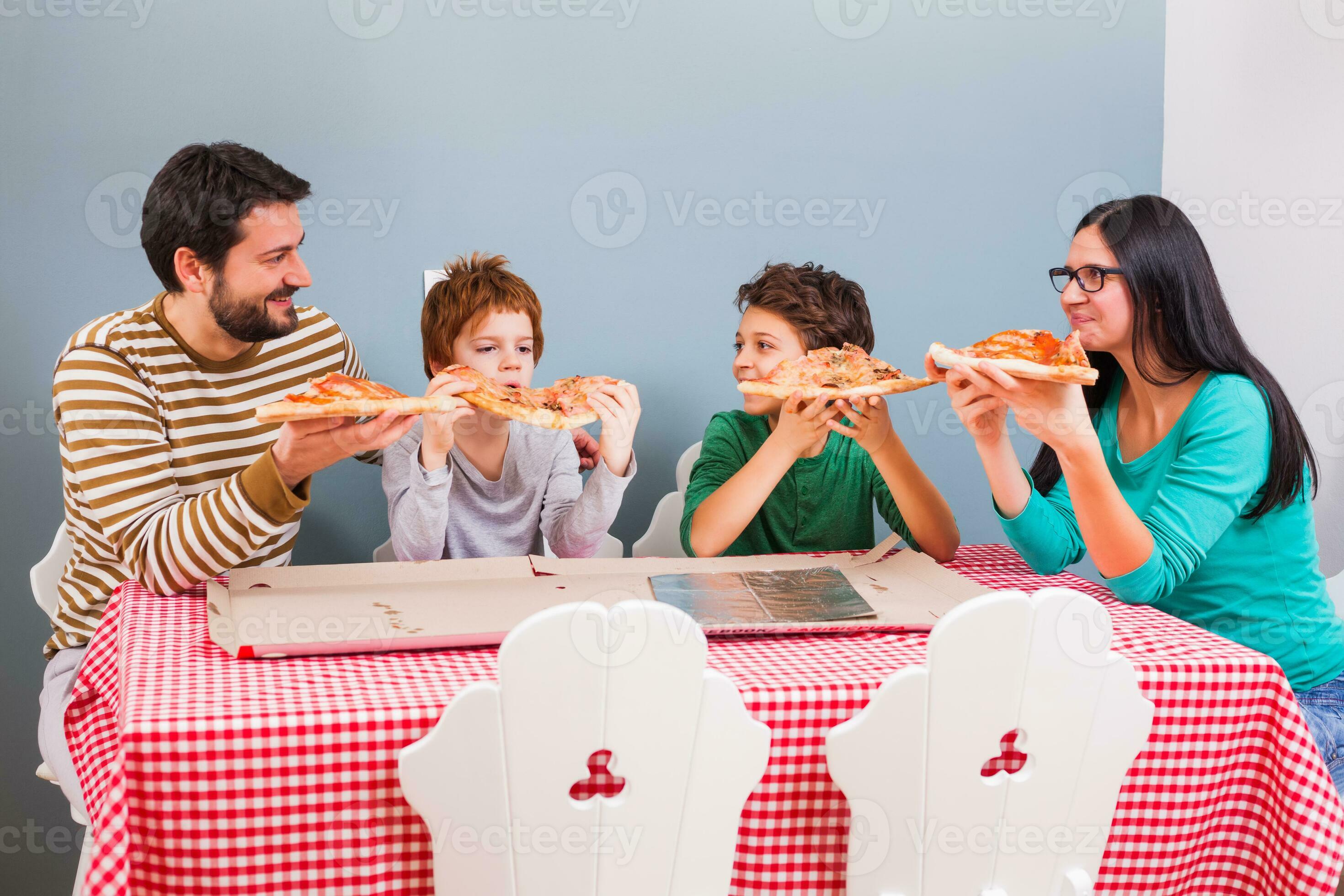 un familia comiendo Pizza 23940189 Foto de stock en Vecteezy