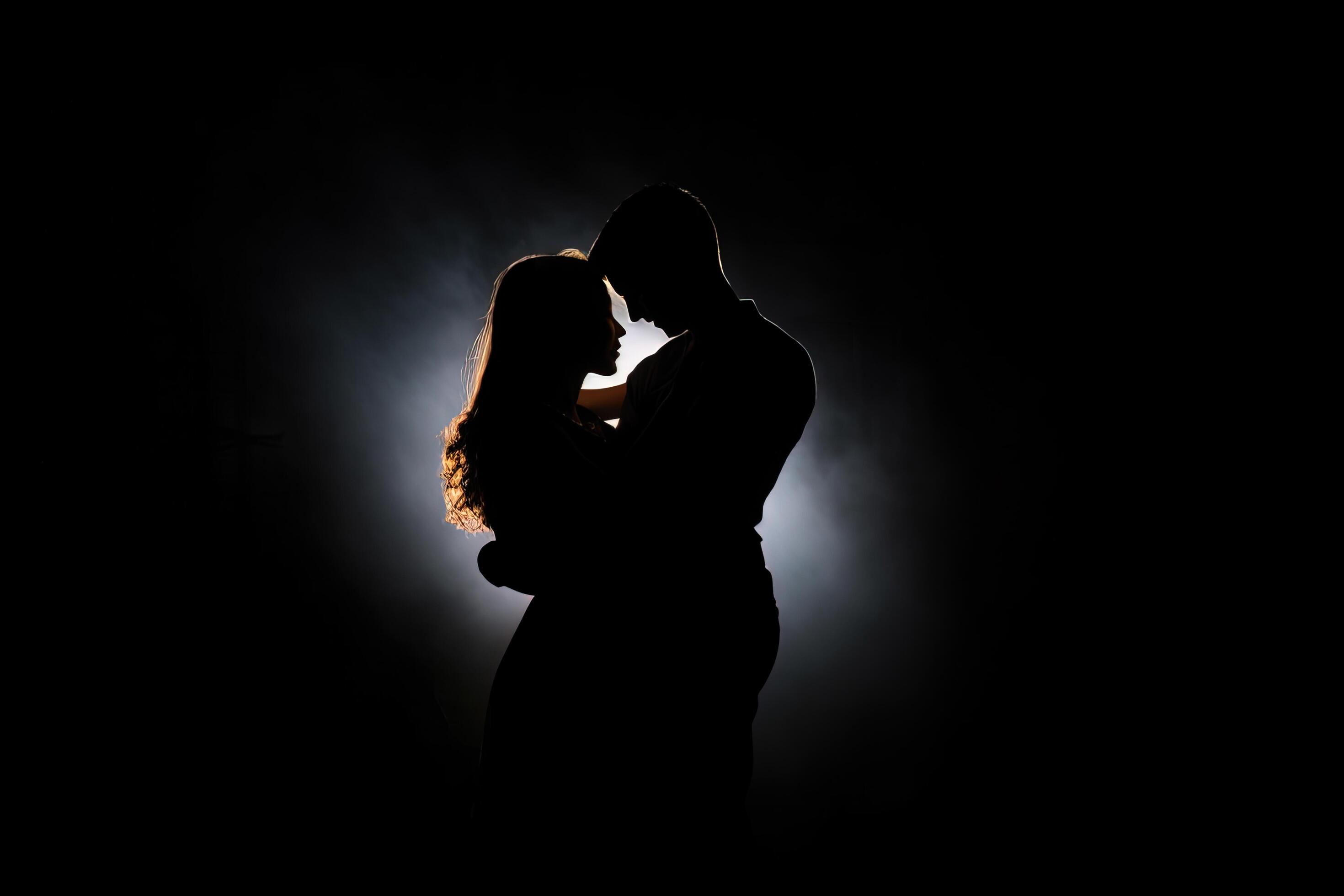 Silhouette of a romantic couple dancing and enjoying in the dark ...