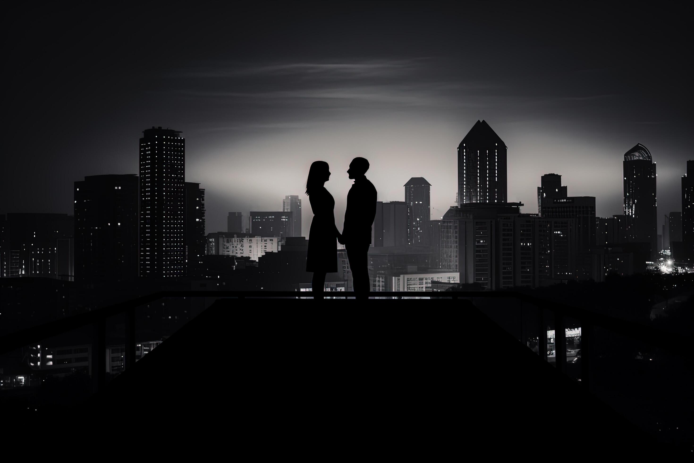 Silhouette of a romantic young couple enjoying the city nightscape ...