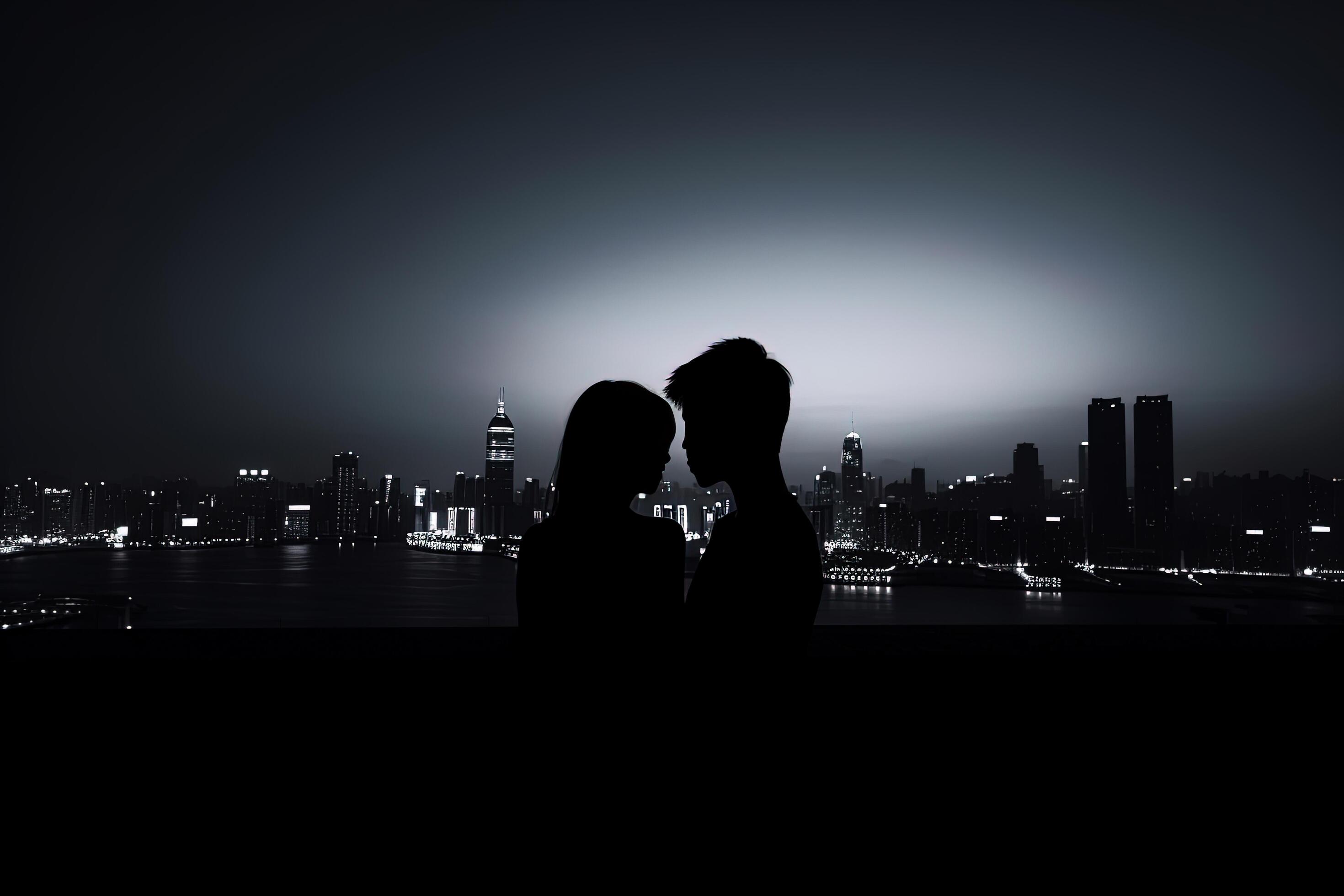 Silhouette of a romantic young couple enjoying the city nightscape ...