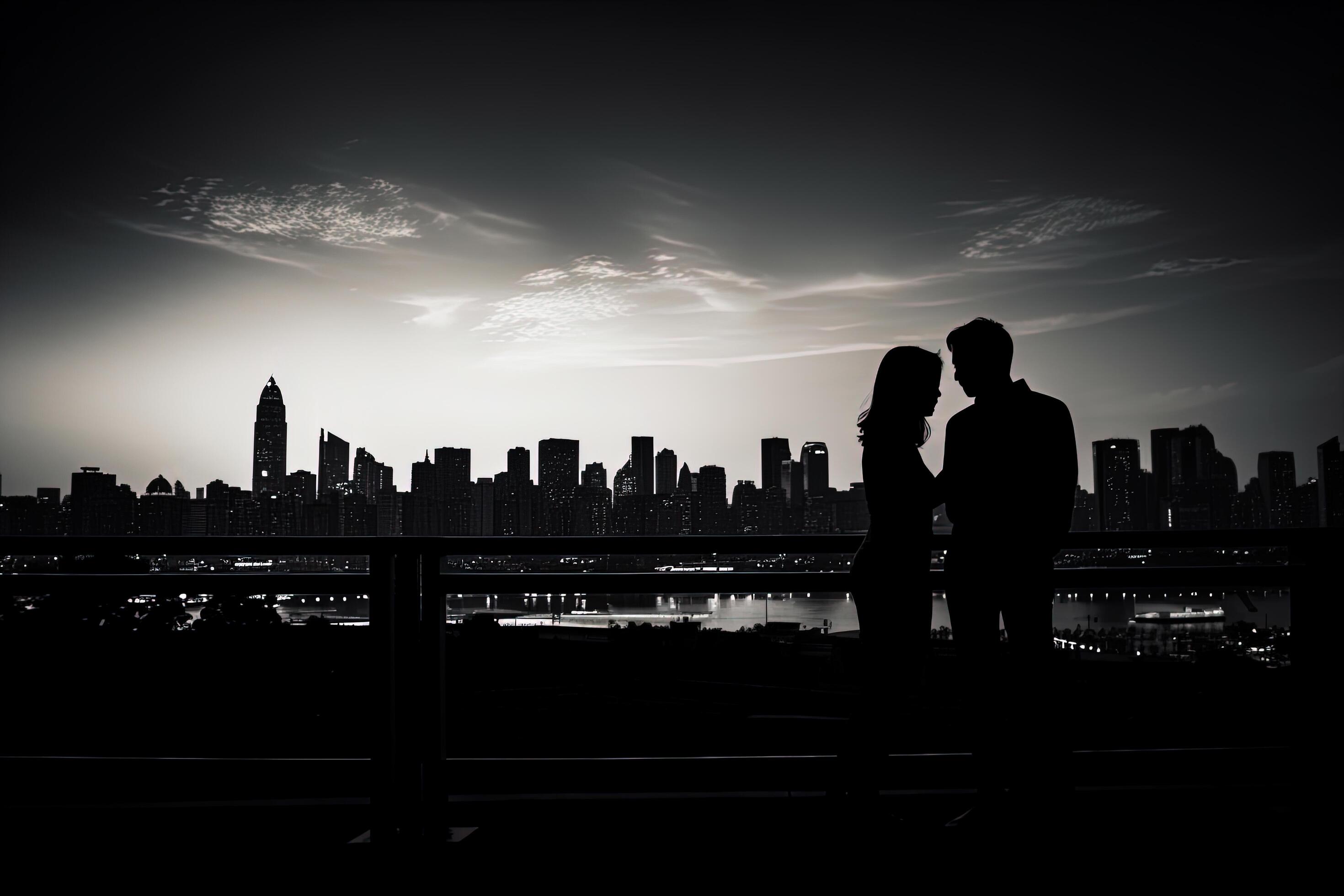 Silhouette of a romantic young couple enjoying the city nightscape ...
