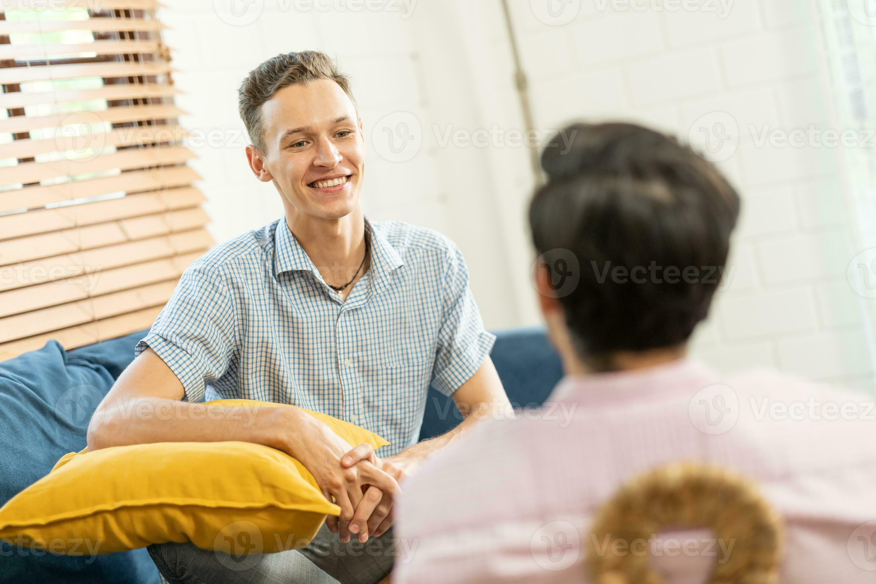 Loving Same Sex Male Couple Lying On Sofa At Home Watching Tv And