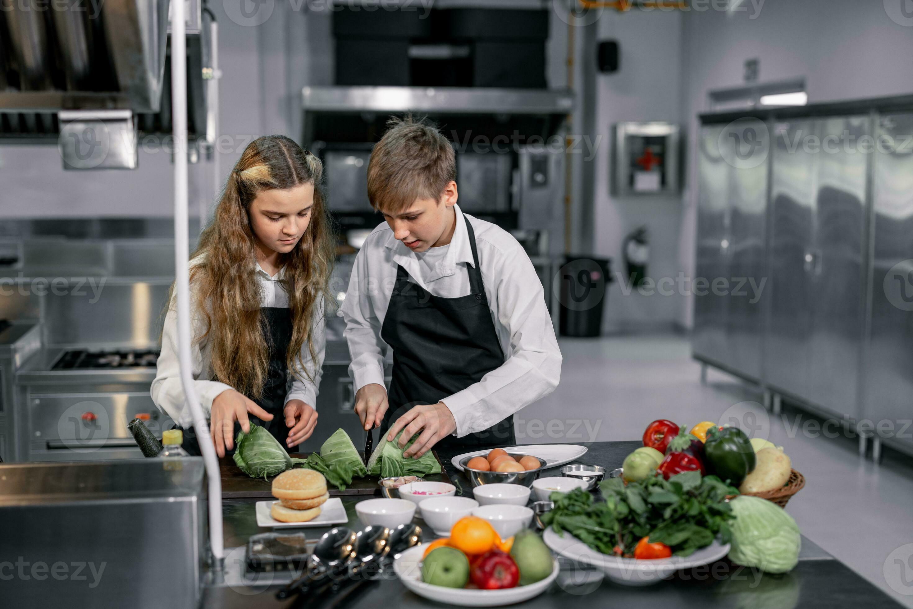 Teenagers learn from expert chefs at culinary school to prepare ingredients and create a variety ...