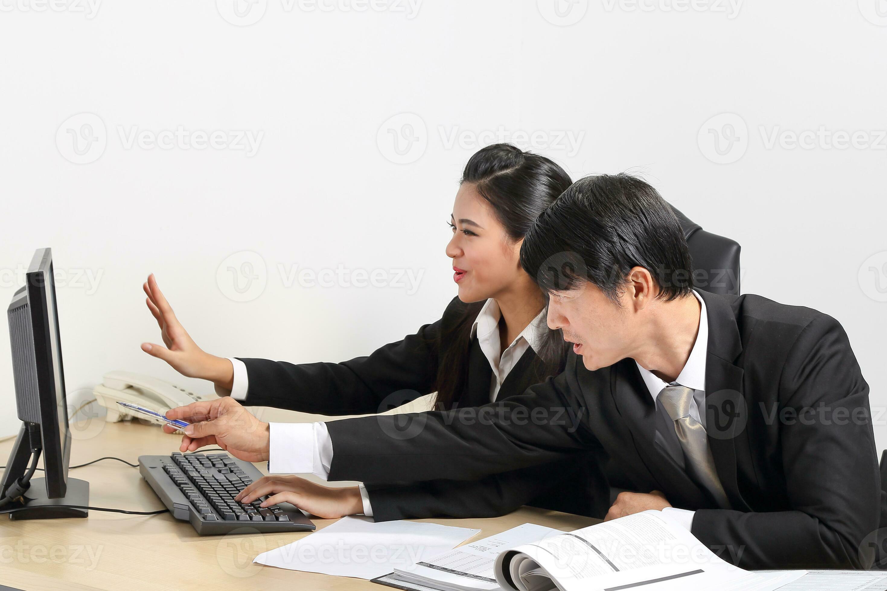 Young Asian male female wearing suit sitting at office desk show point computer monitor ...