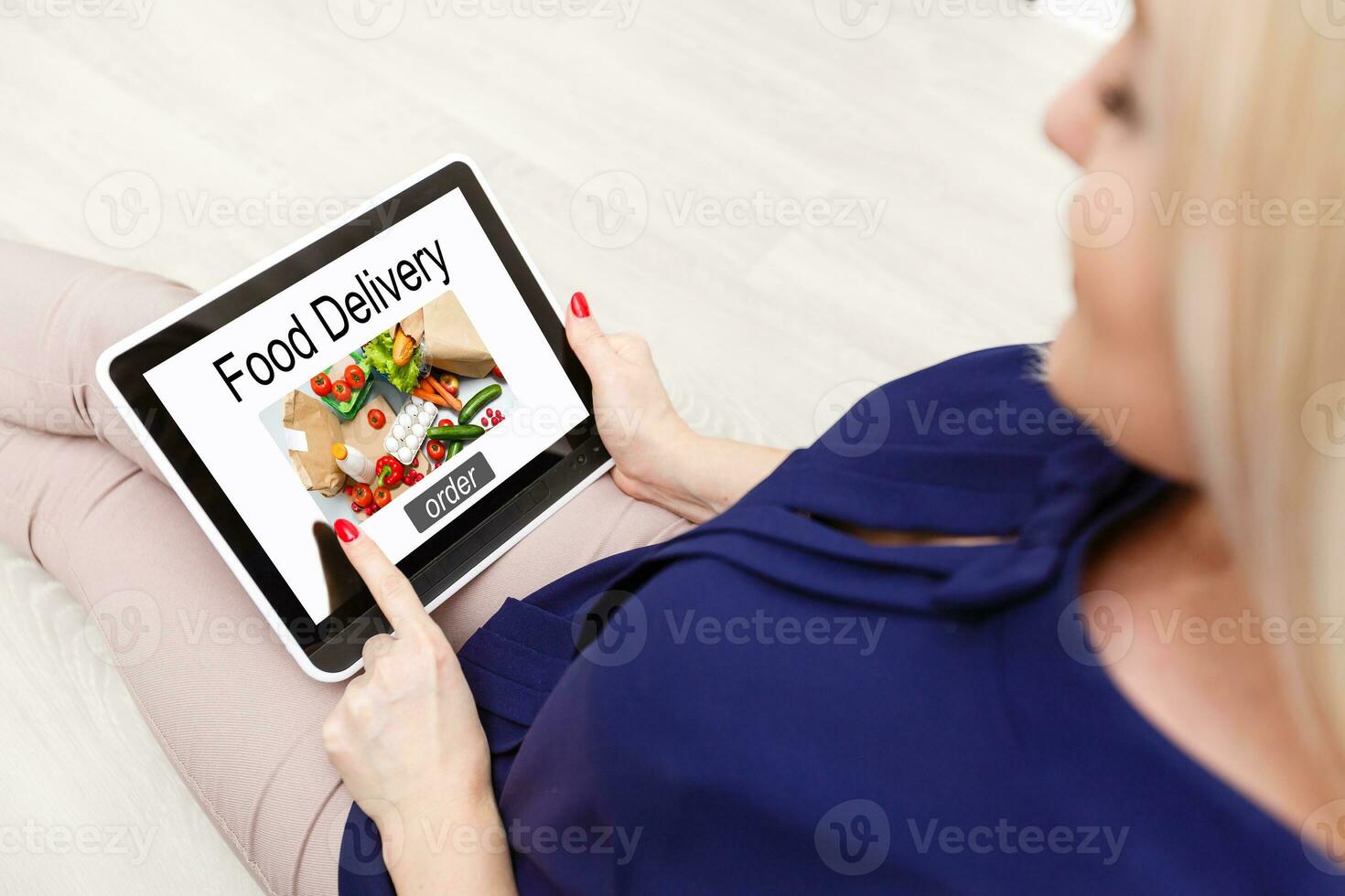 Girl ordering pizza online on smartphone, with table and coffee and plant in background 24494248 ...