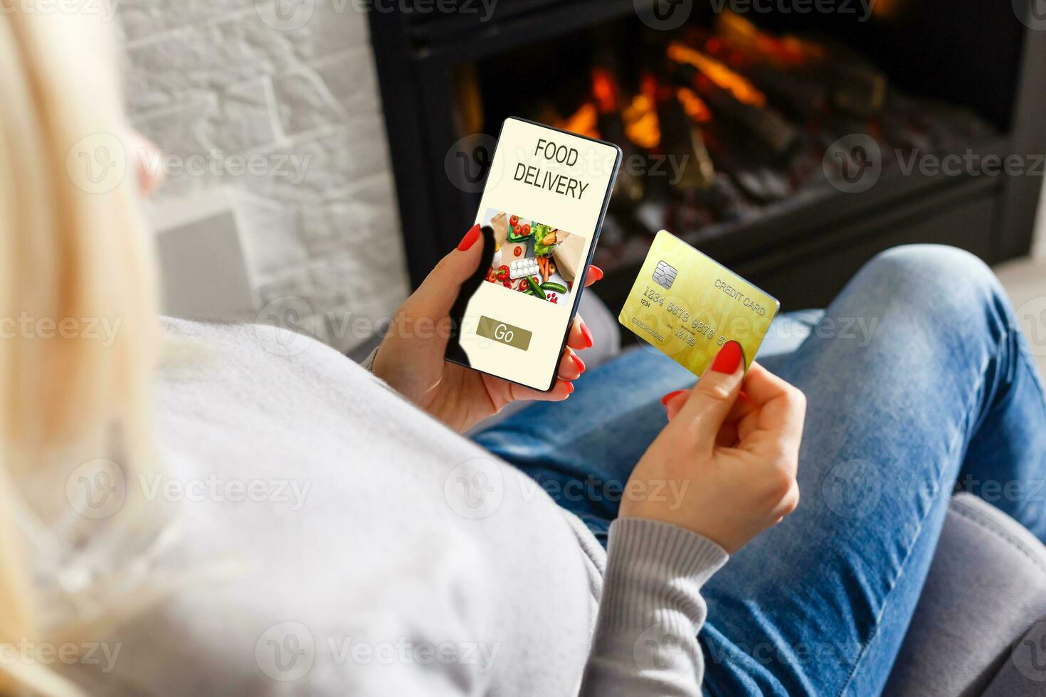 Girl ordering pizza online on smartphone, with table and coffee and plant in background 24497100 ...