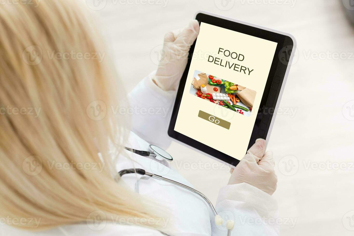 Girl ordering pizza online on smartphone, with table and coffee and plant in background 24497106 ...