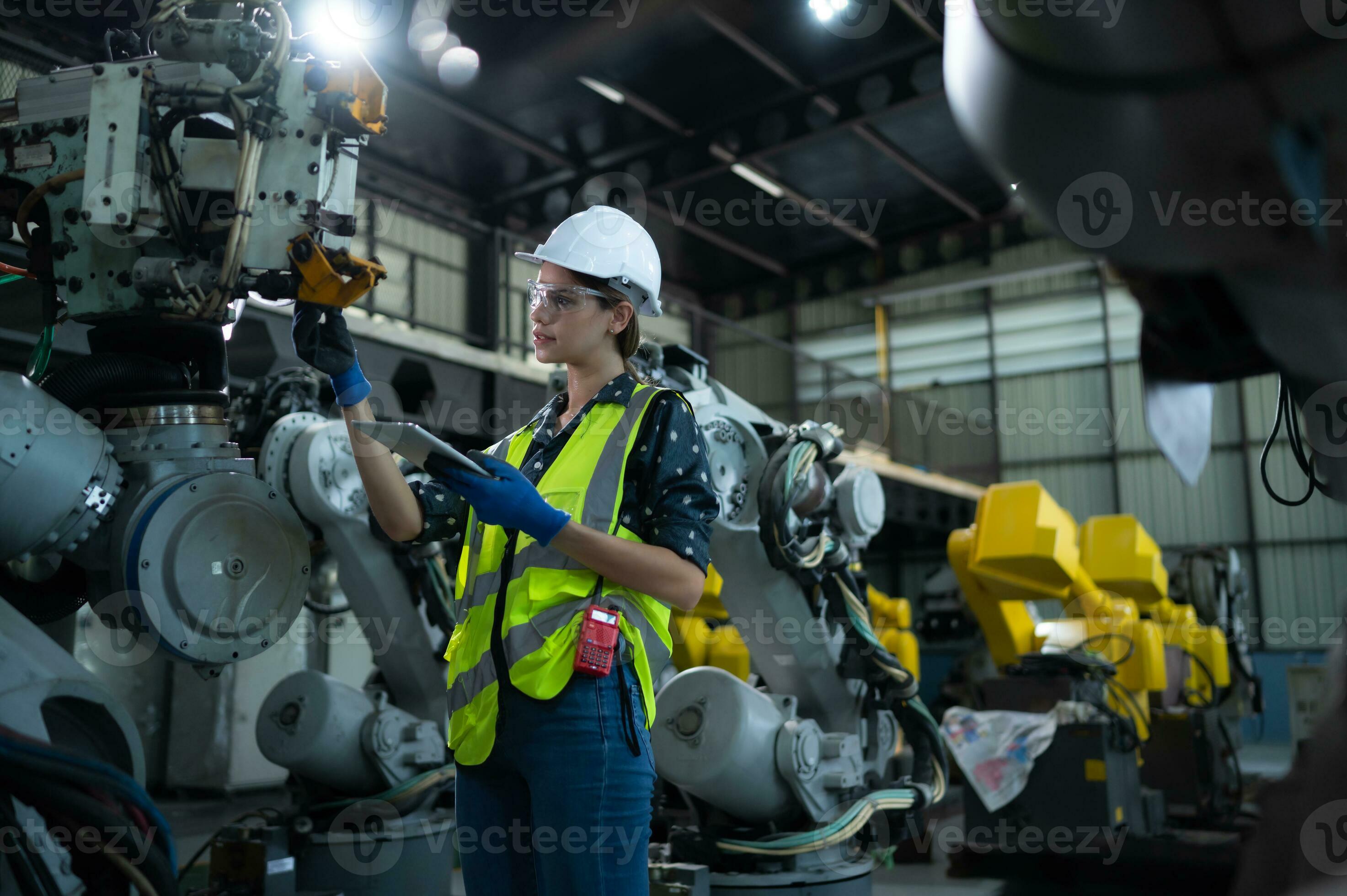 A female engineer installs a program on a robotics arm in a robot ...