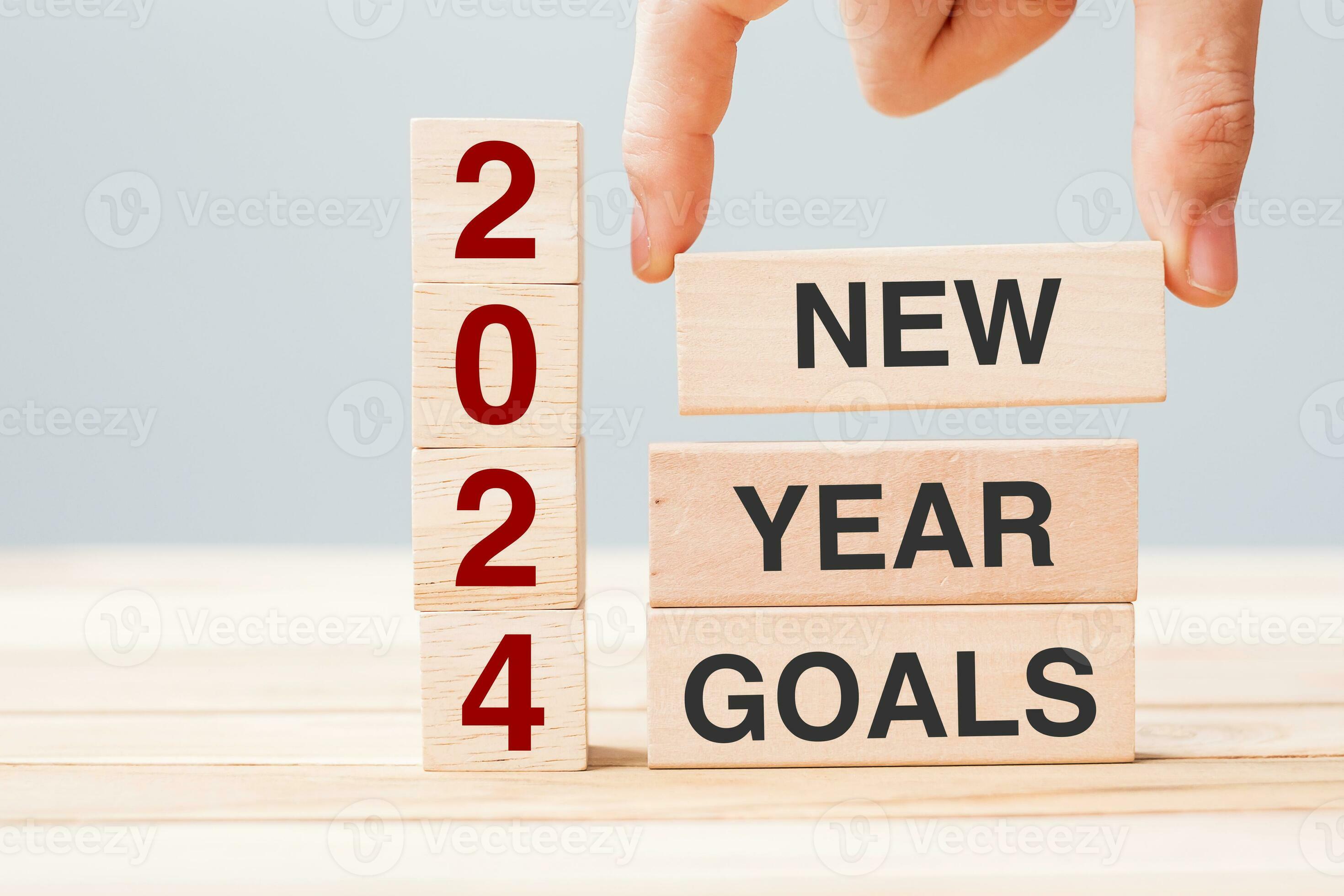Hand Holding Wooden Block With Text 2024 New Year New Goals On Table