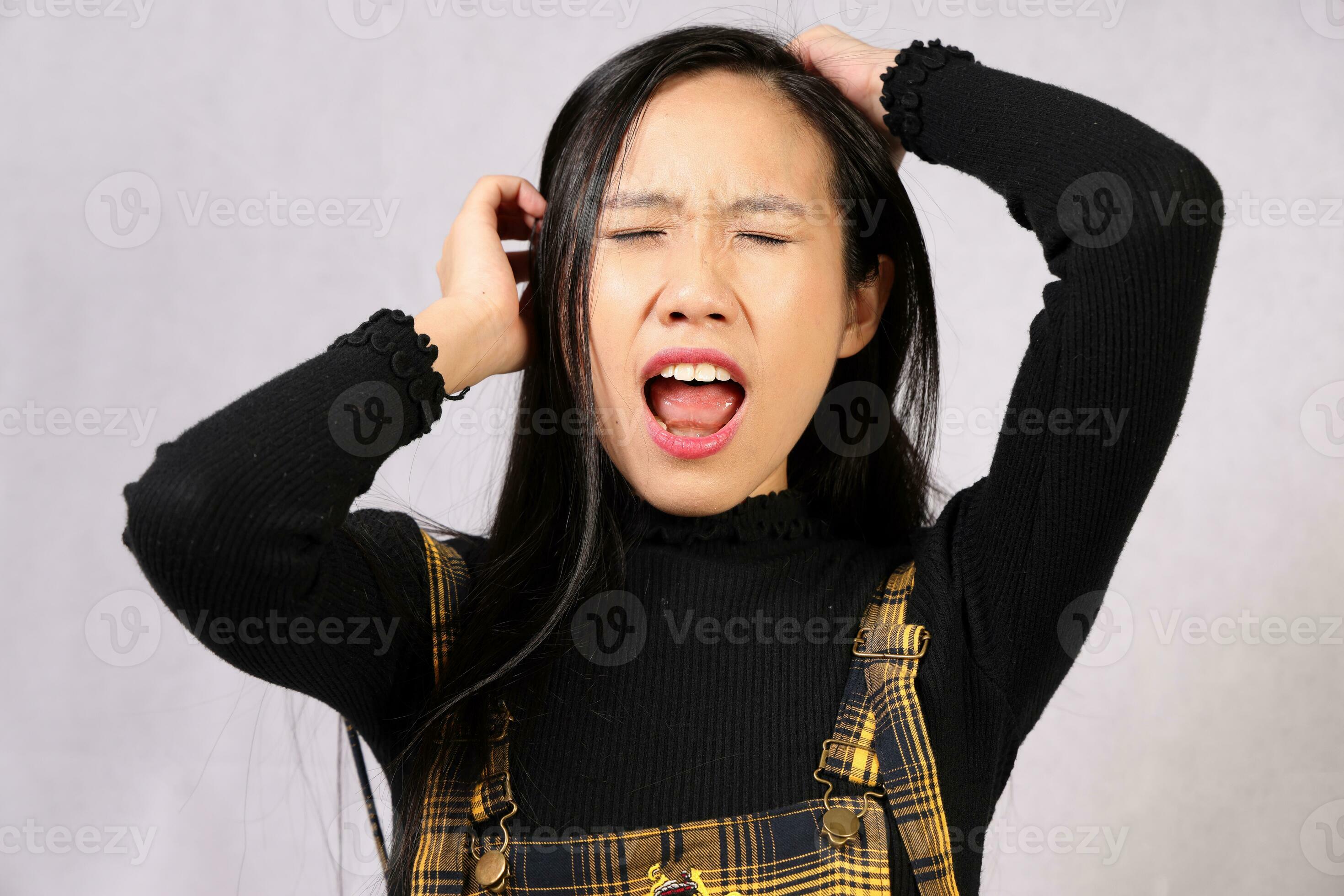 Young attractive southeast Asian woman posing facial expression angry crazy mad pain eye close ...
