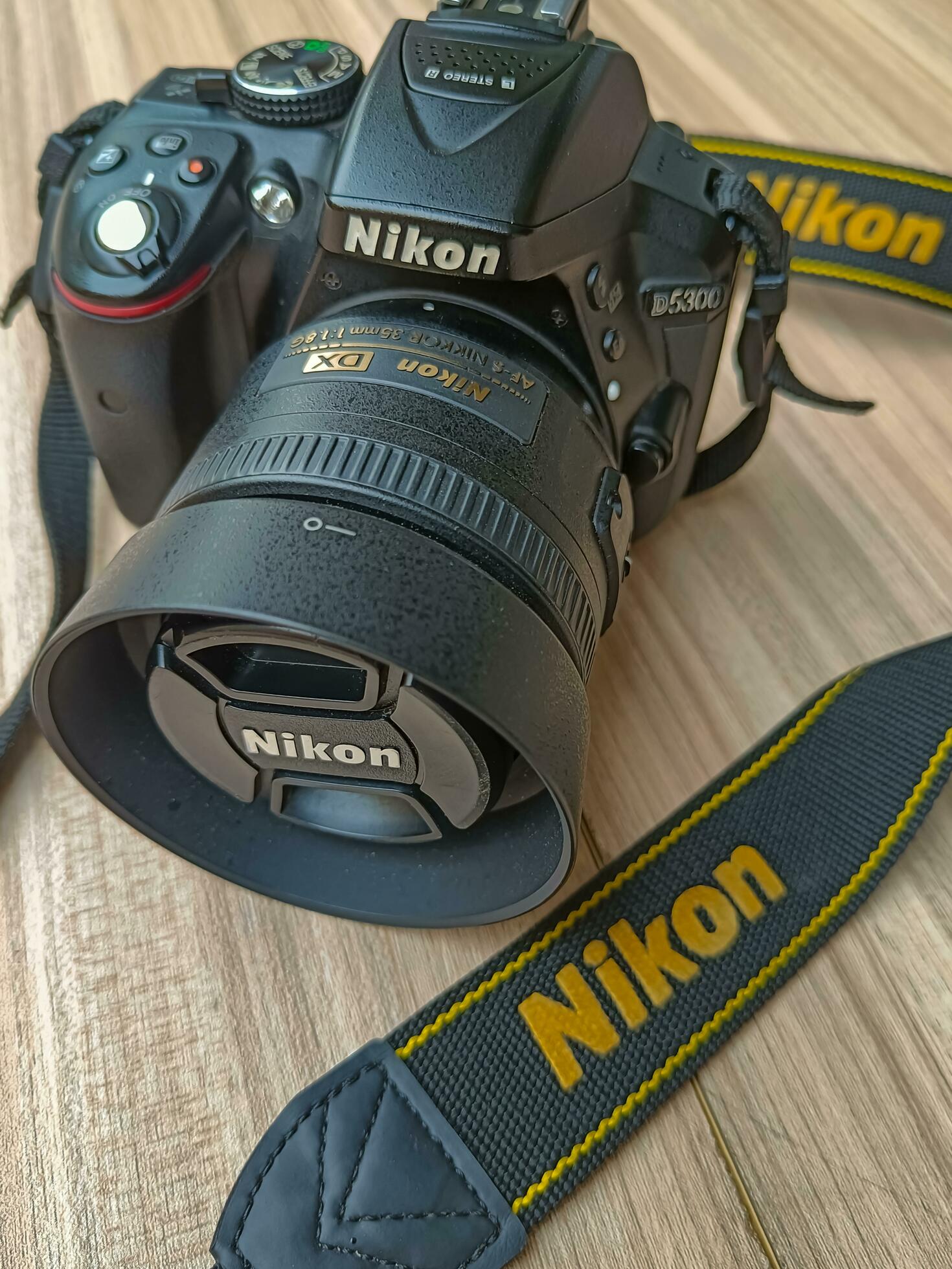 New Delhi, India, May 28 2023 - Nikon D5300 camera with 35mm f2.8 prime lens on plain background ...