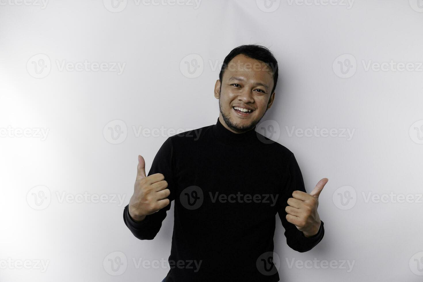 Excited Asian man wearing black shirt gives thumbs up hand gesture of ...