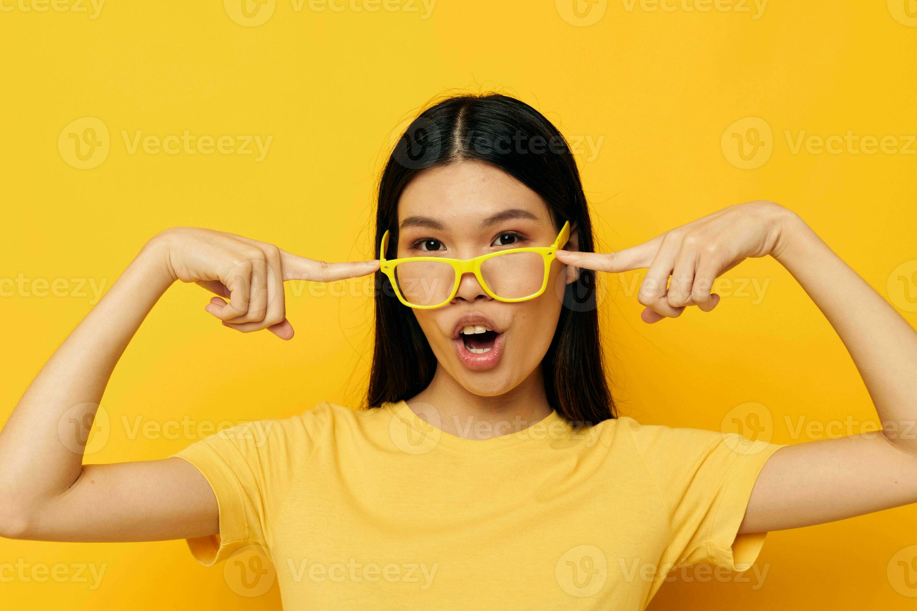 Woman With Asian Appearance In Yellow T Shirts With Glasses Posing