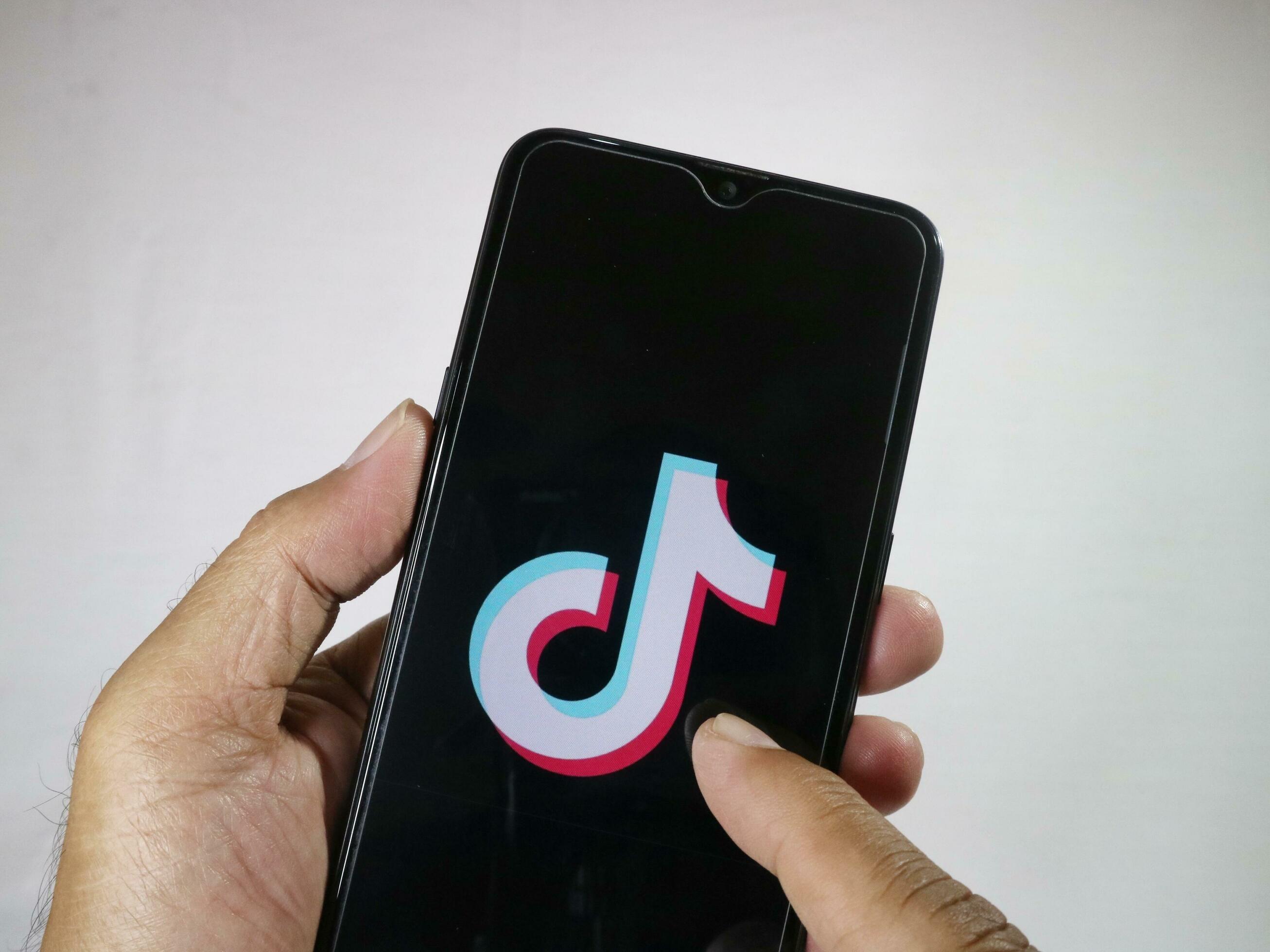 Jakarta, Indonesia, 2023. Hand holding mobile phone with finger touch ... Jakarta, Indonesia, 2023. Hand holding mobile phone with finger touch ...