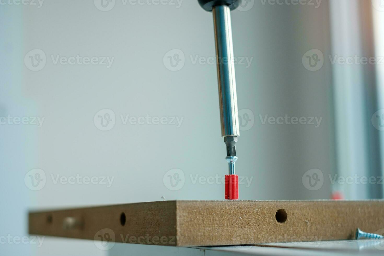 man using screwdriver assembling or repairing furniture at home. DIY ...