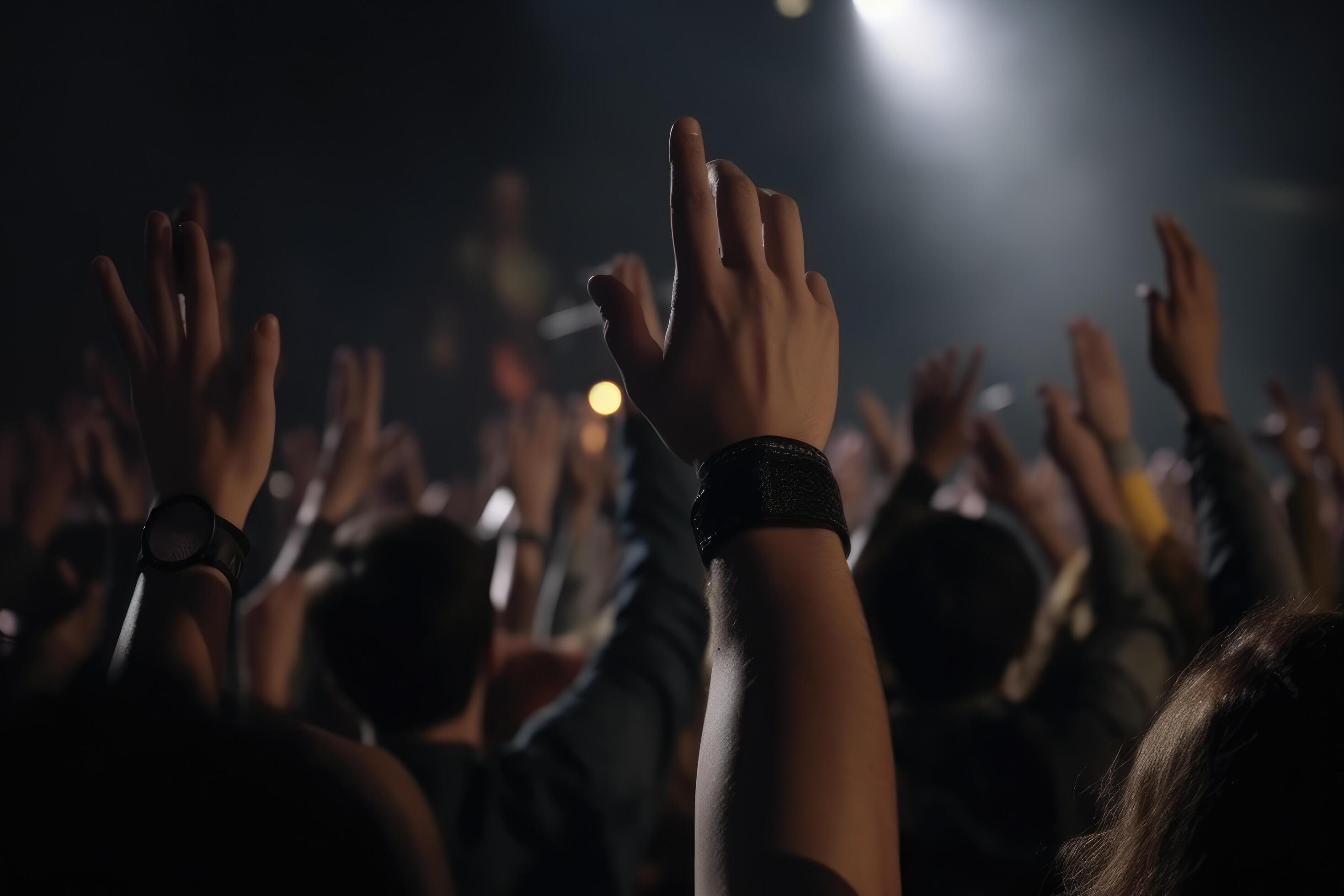 The crowd at a concert in front of the stage with hands raised up, Peoples closeup rear view ...