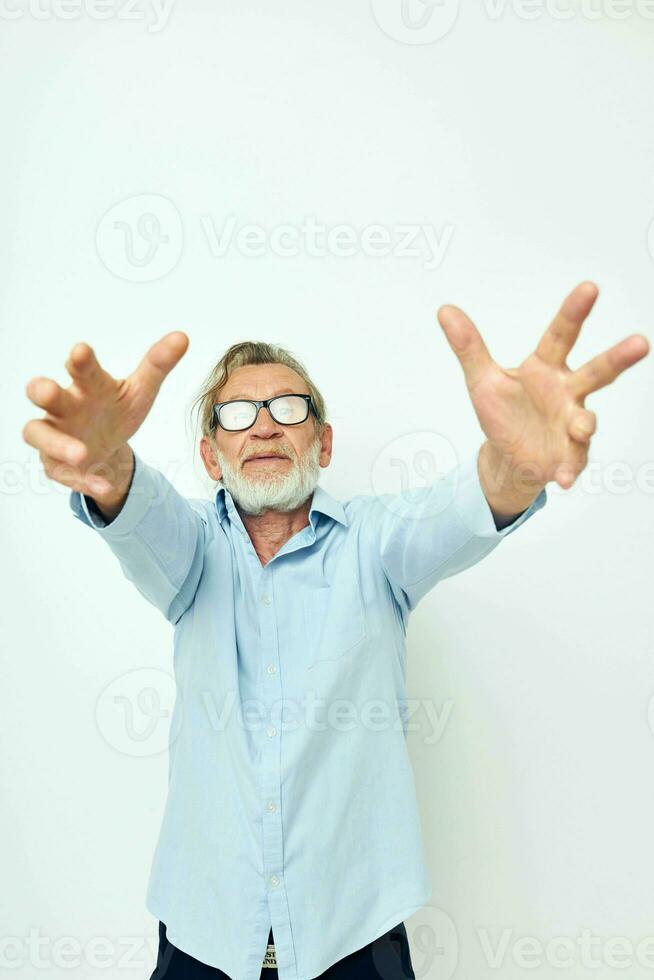 Photo of retired old man in blue shirts gestures with his hands ...