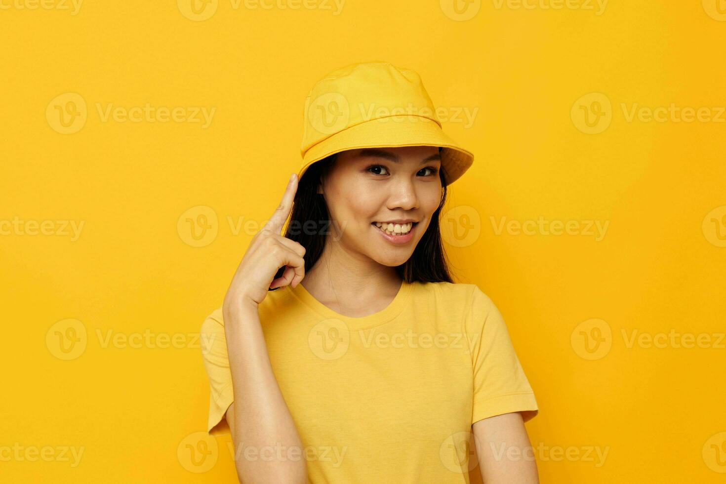 Woman With Asian Appearance In A Yellow T Shirt And Hat Posing Emotions