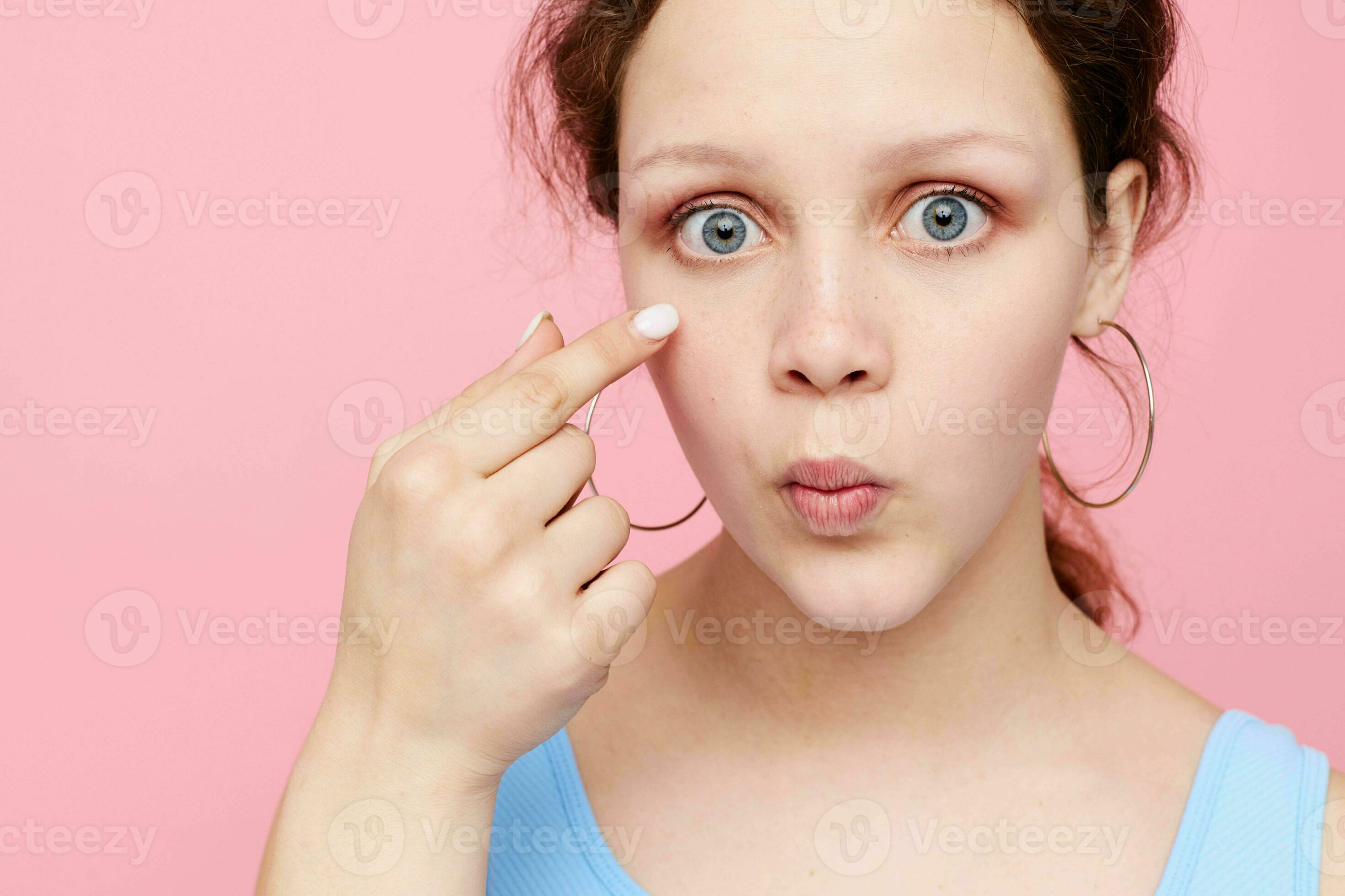 pretty woman grimace close-up emotions earrings posing pink background ...