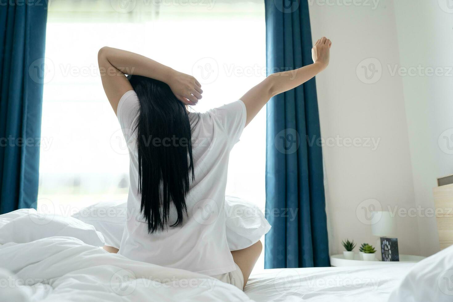 Asian woman Beautiful young stretching in the morning at bedroom after waking up in her bed ...