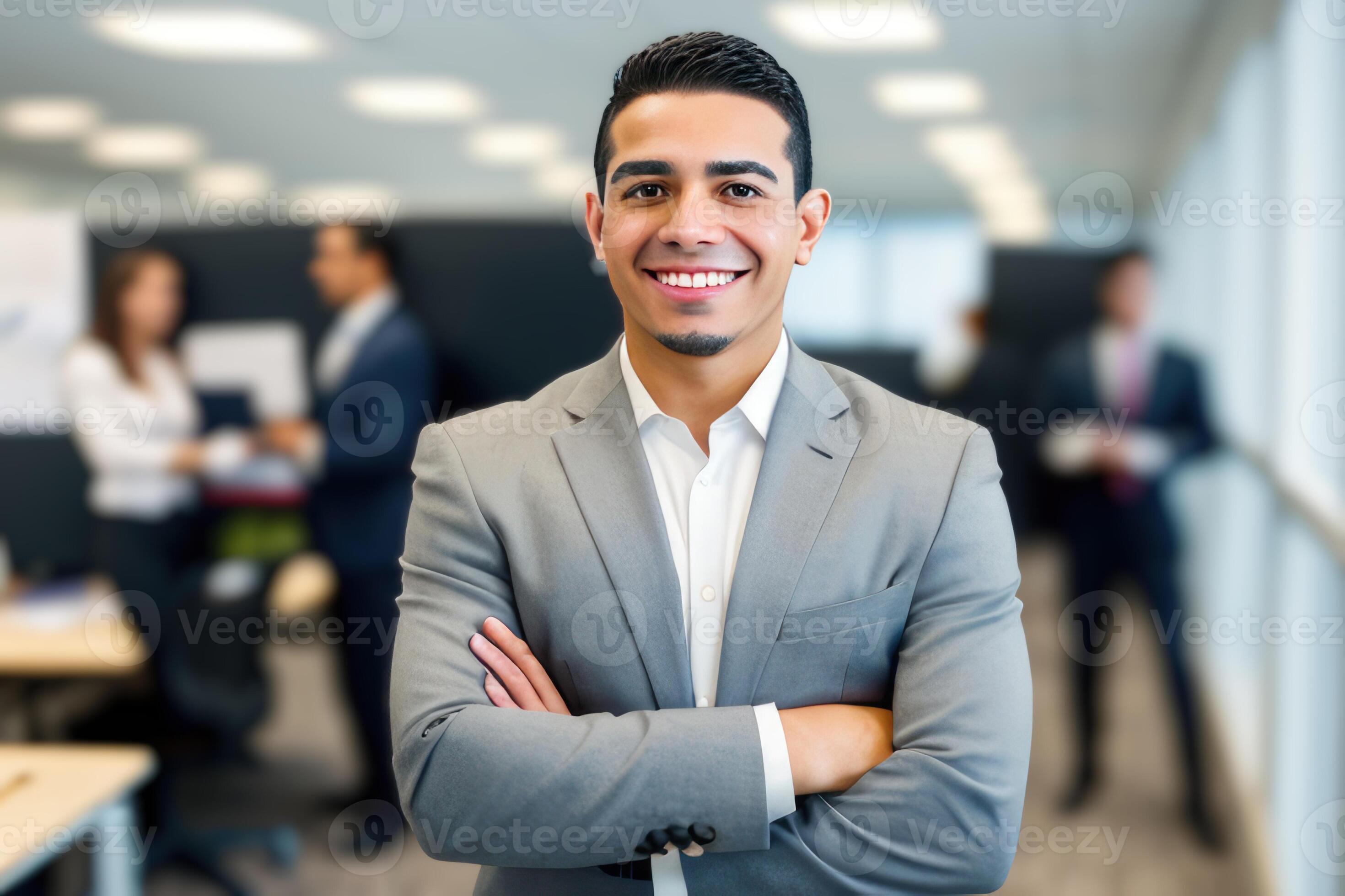Young smart businessman, standing in blur background of office ...