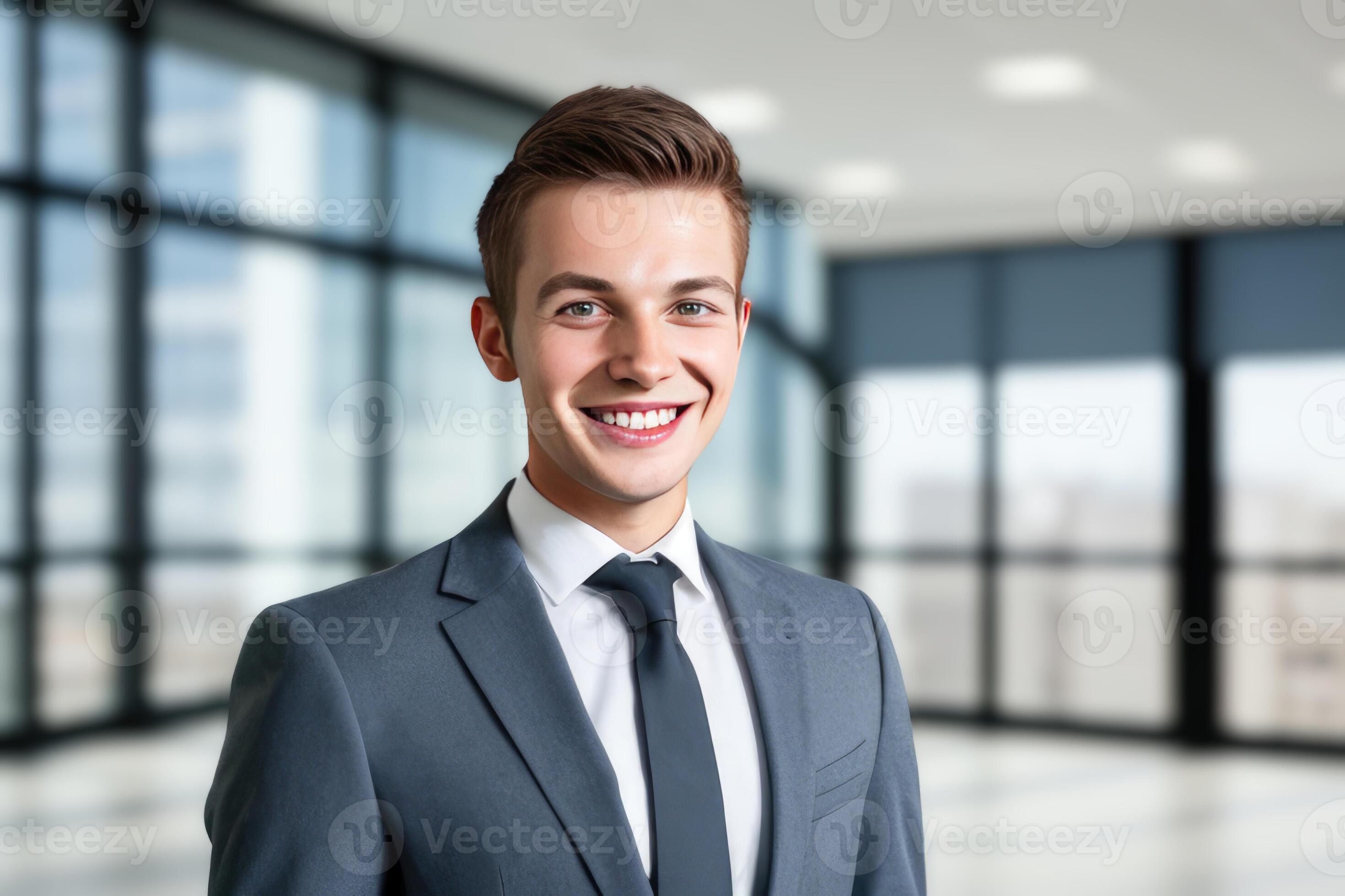 Young smart businessman, standing in blur background of office ...