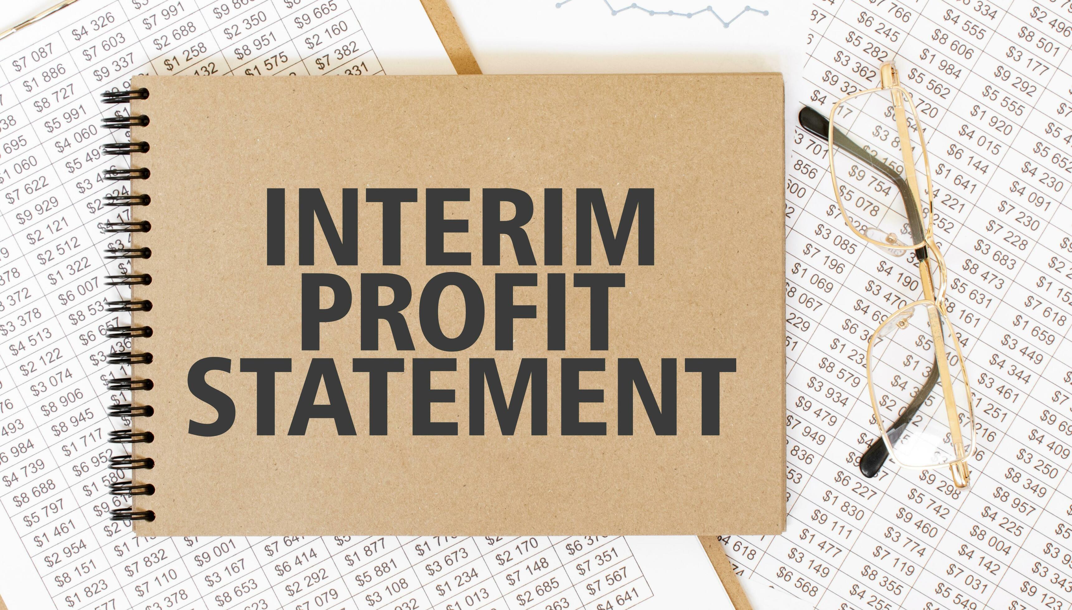 Craft colour notepad with text INTERIM PROFIT STATEMENT Notepad with eyeglasses and text ...