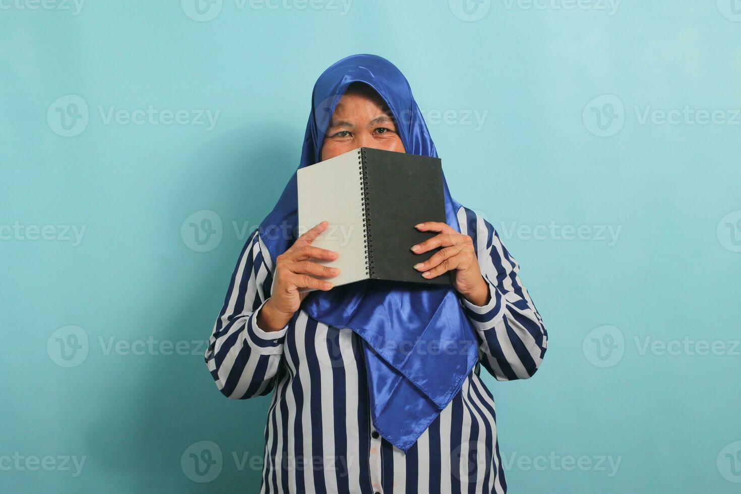Excited Asian Middle Aged Woman Wearing A Blue Hijab And A Striped