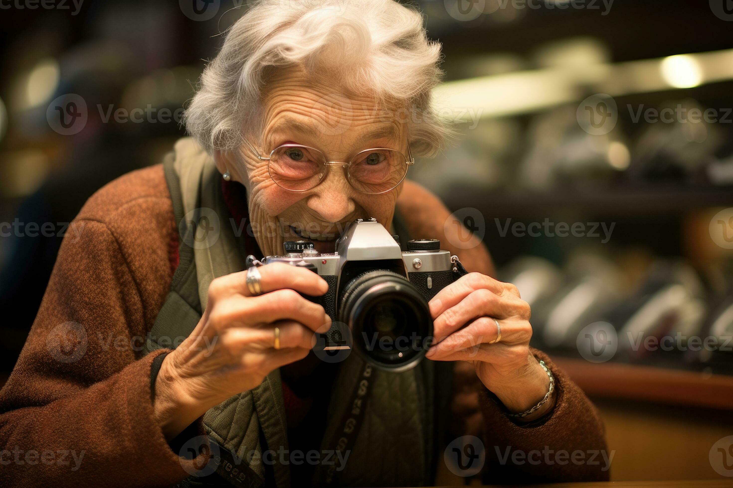 An elderly woman using a camera and a photography hobby, demonstrating ...