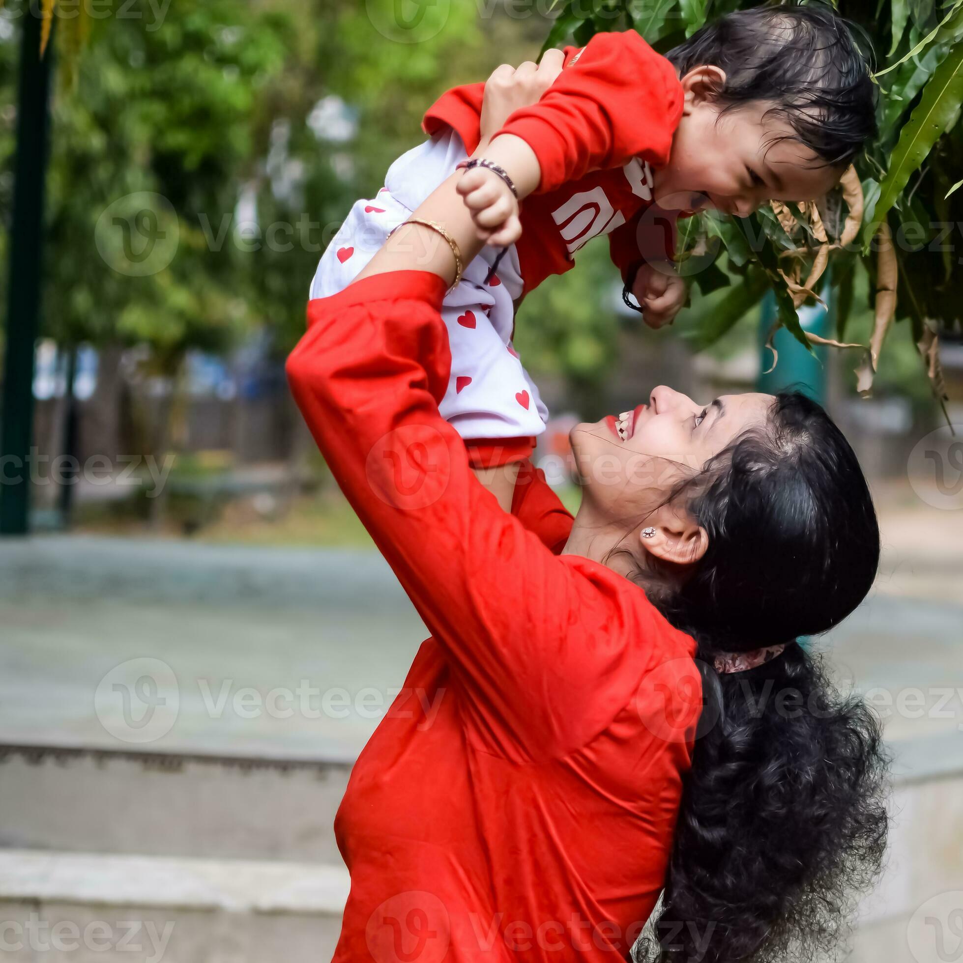 Loving mom carrying of her baby at society park. Bright portrait of happy mum holding child in ...
