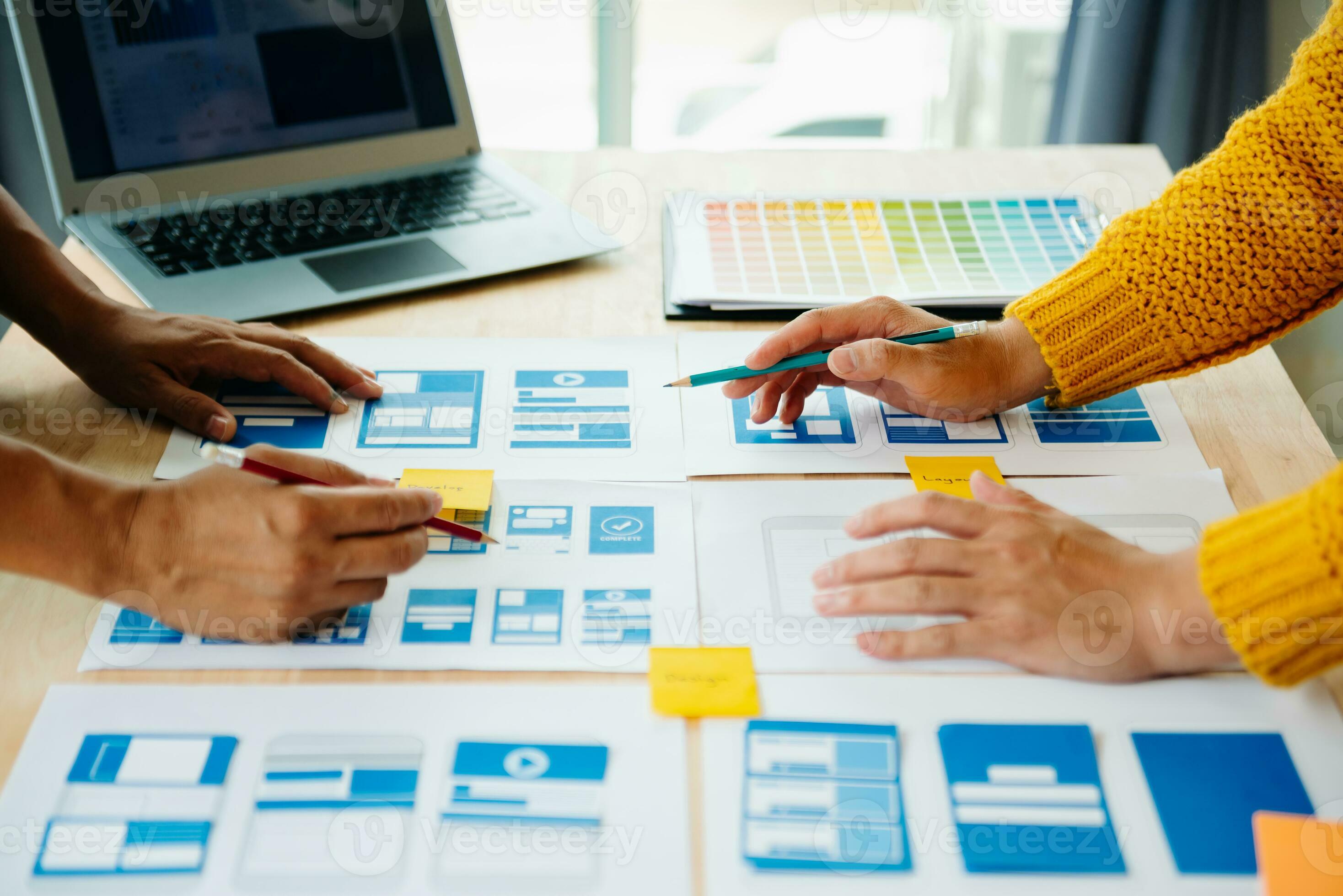 View of UI developer team brainstorming on their project with laptop, smartphone and digital ...