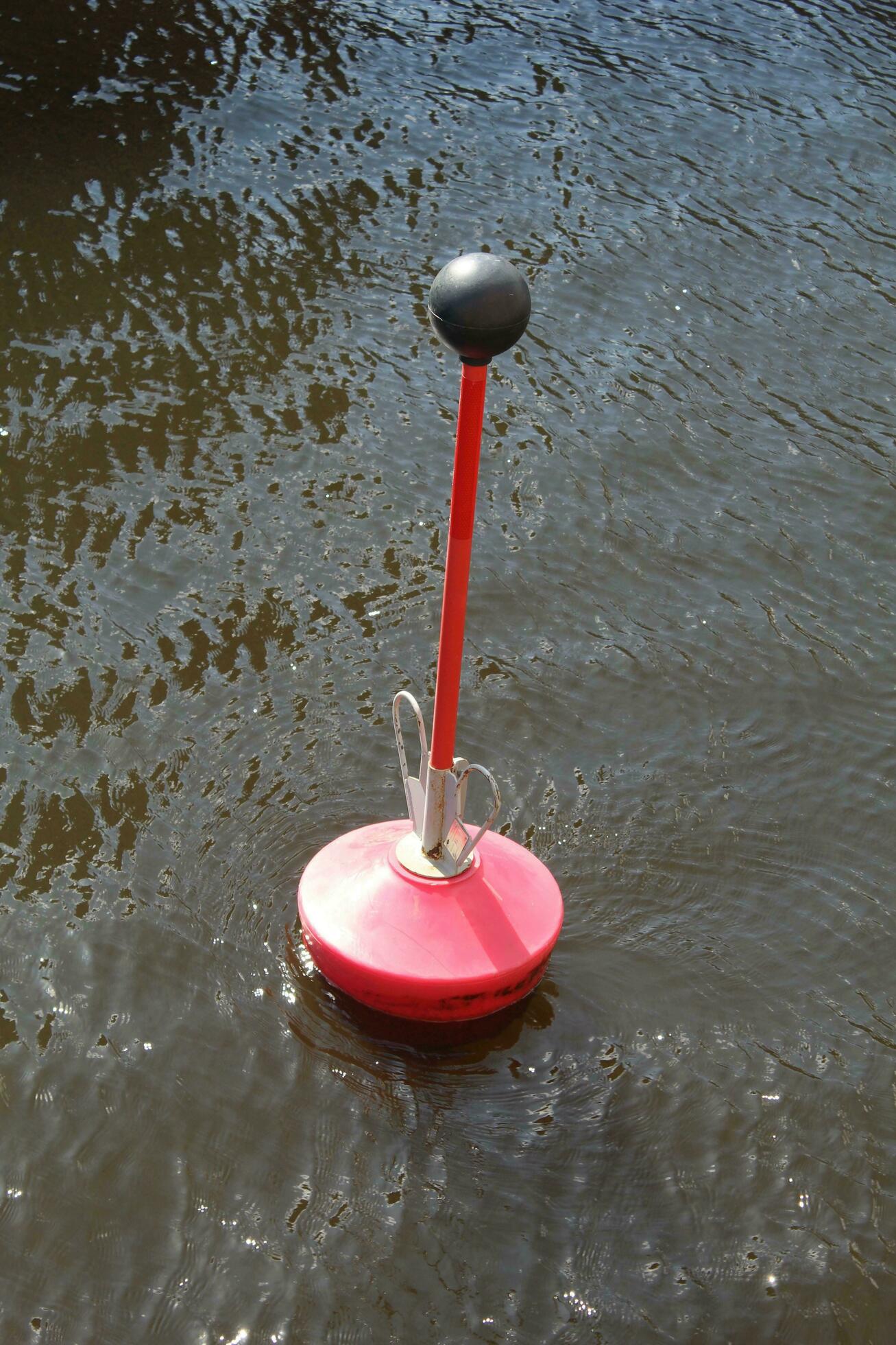 A red buoy floats on the surface of the river 27004620 Stock Photo at ...