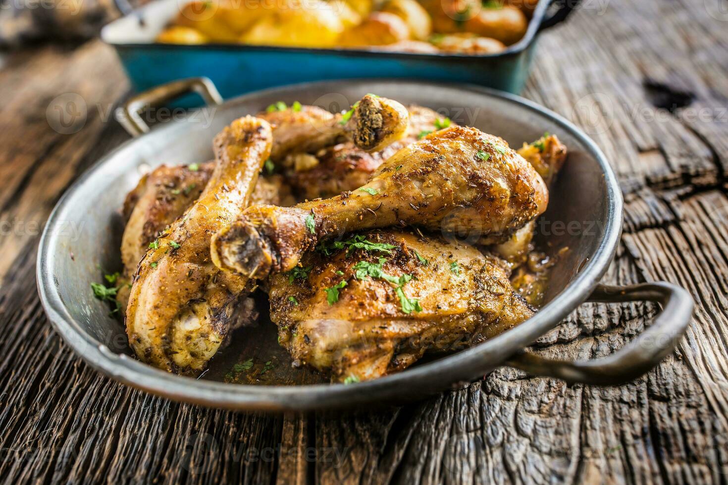 Roasted chicken legs in pan on rustic oak table 27490812 Stock Photo at Vecteezy