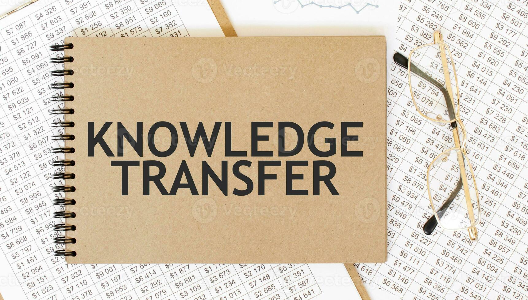 Craft colour notepad with text KNOWLEDGE TRANSFER. Notepad with eyeglasses and text documents ...
