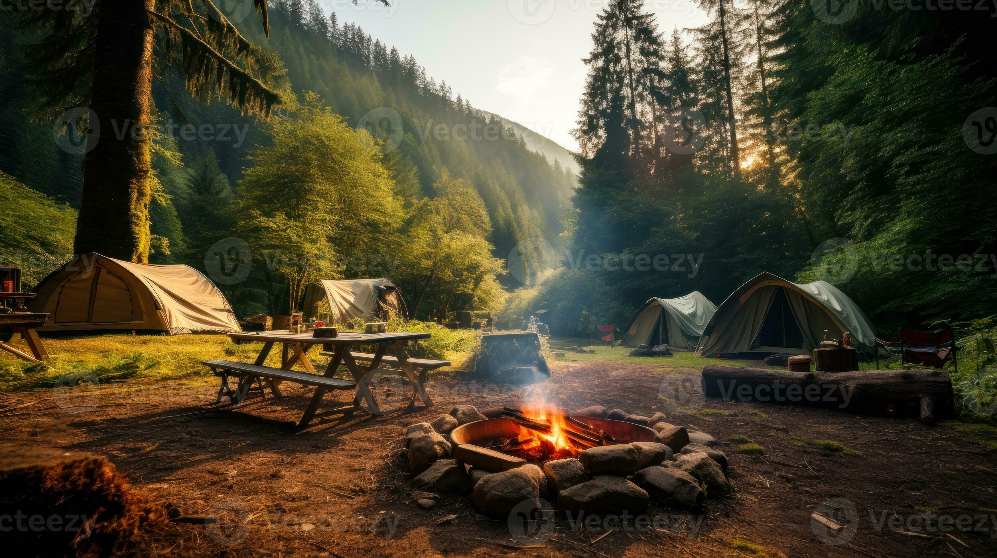 campground with cozy campfire in the campsite in the forest, outdoor recreation concept ...