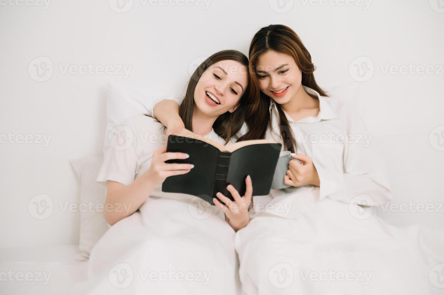 Attractive Lesbian Couple Use Mobile Phone Tablet Watch Movie On Bed