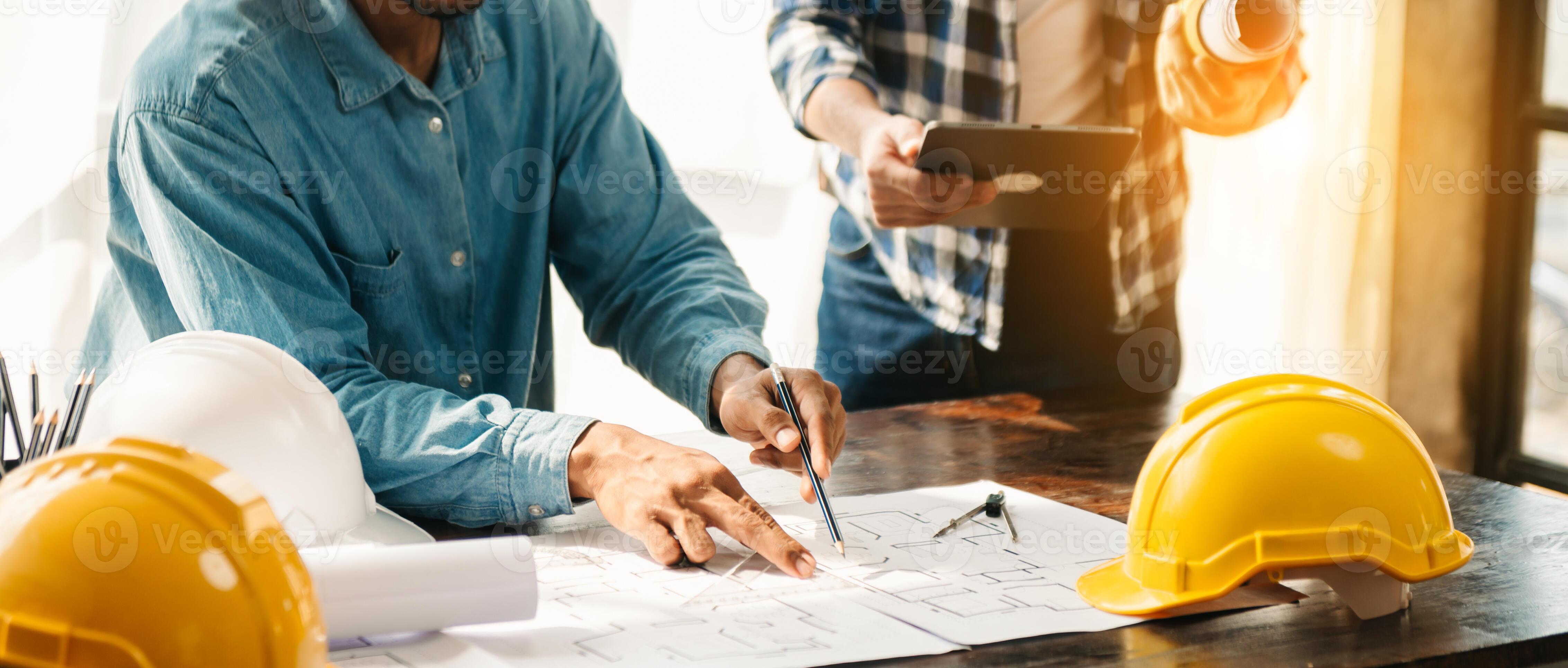 Engineer teams meeting working together wear worker helmets hardhat on construction site in ...