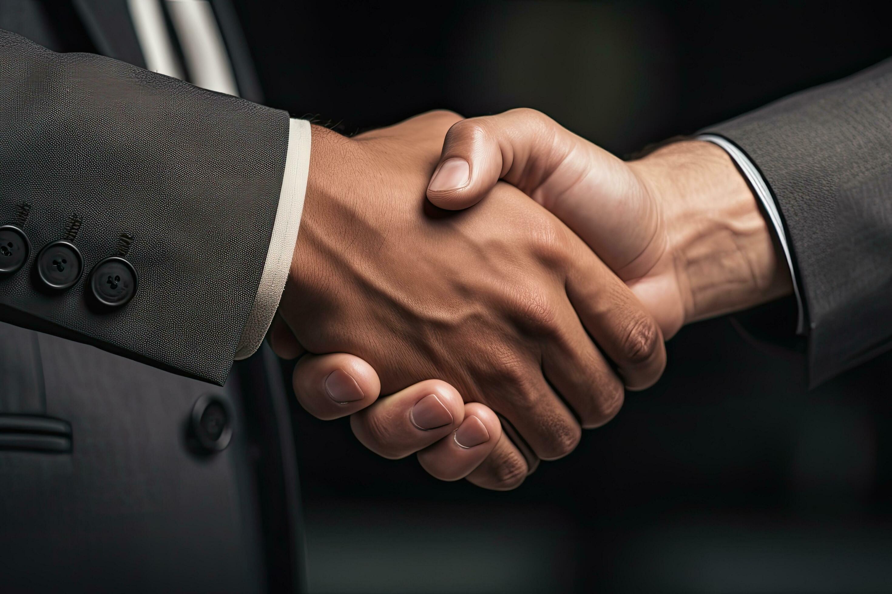 Close-up of two businessmen shaking hands in office. Shaking hands ...