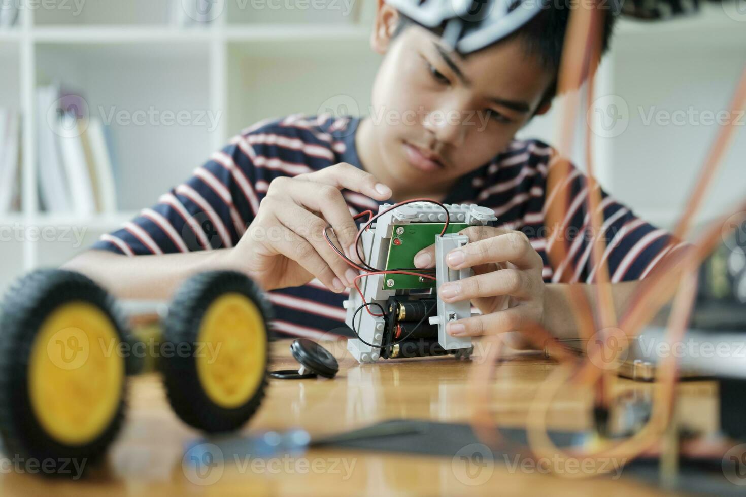 Asian teenager doing robot project in science classroom. technology of robotics programing and ...