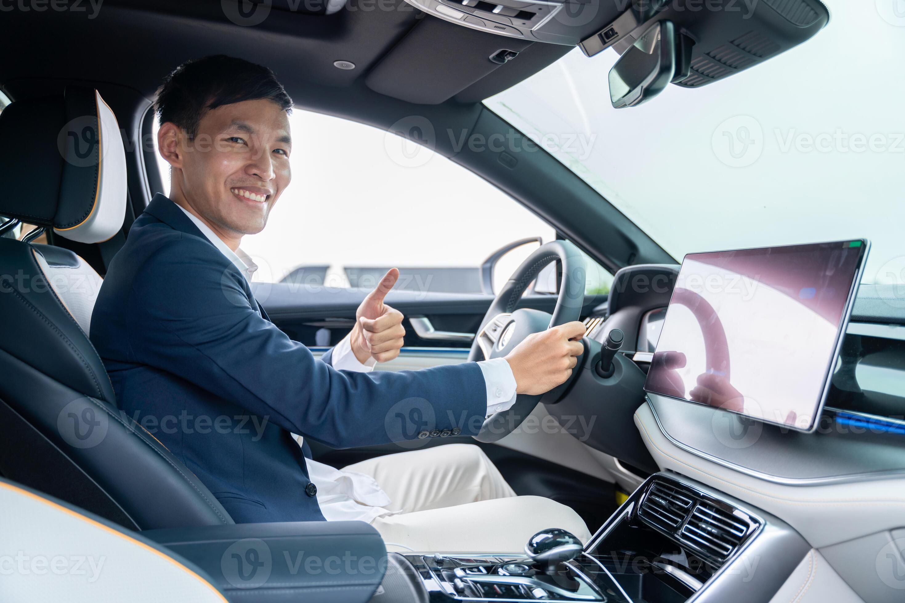 Happy businessman driving car before buying new electric vehicle with thumbs up. Electric car ...
