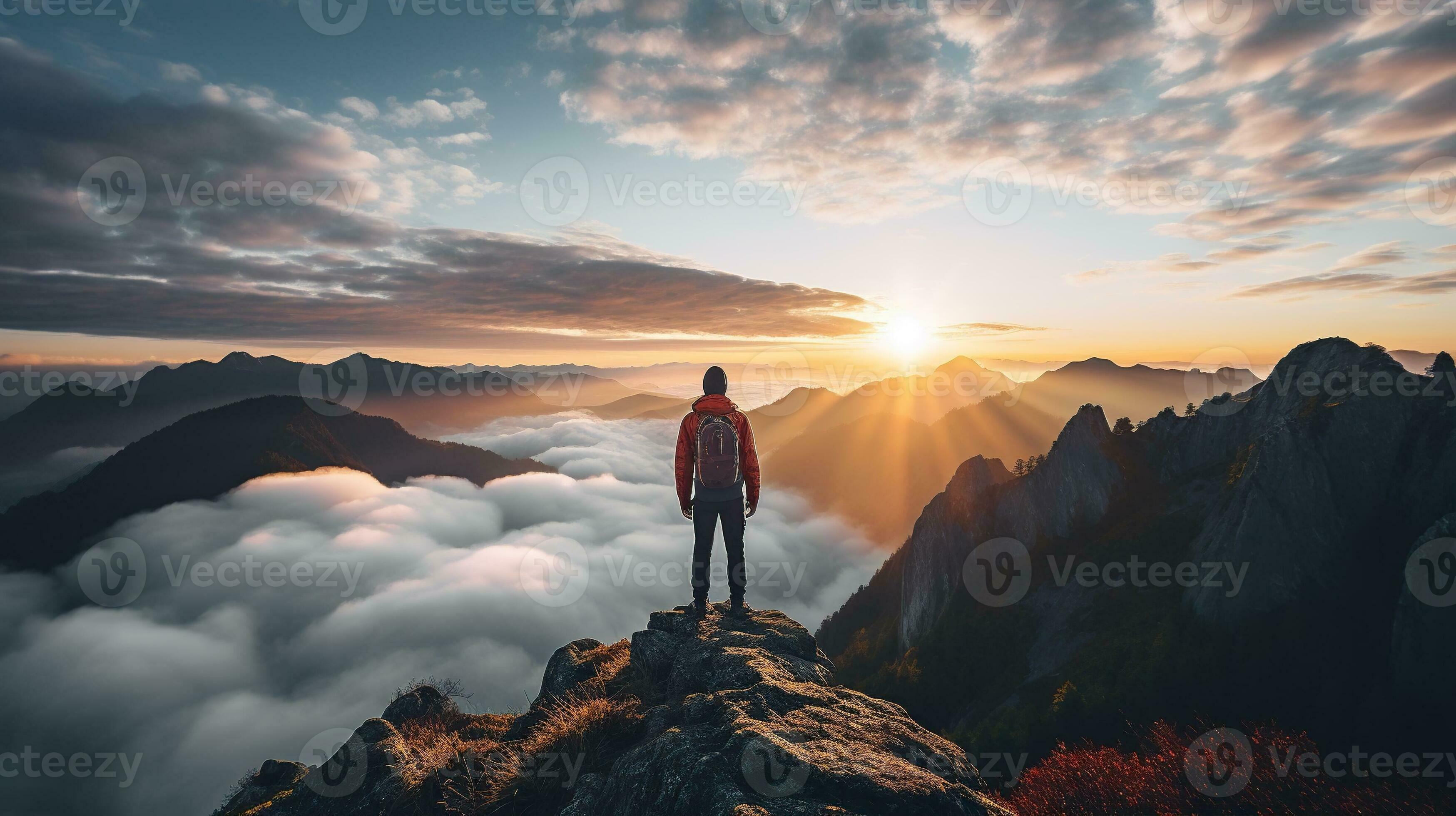 a man on top of a mountain peak with view of clouds and sunrise 29136111 Stock Photo at Vecteezy