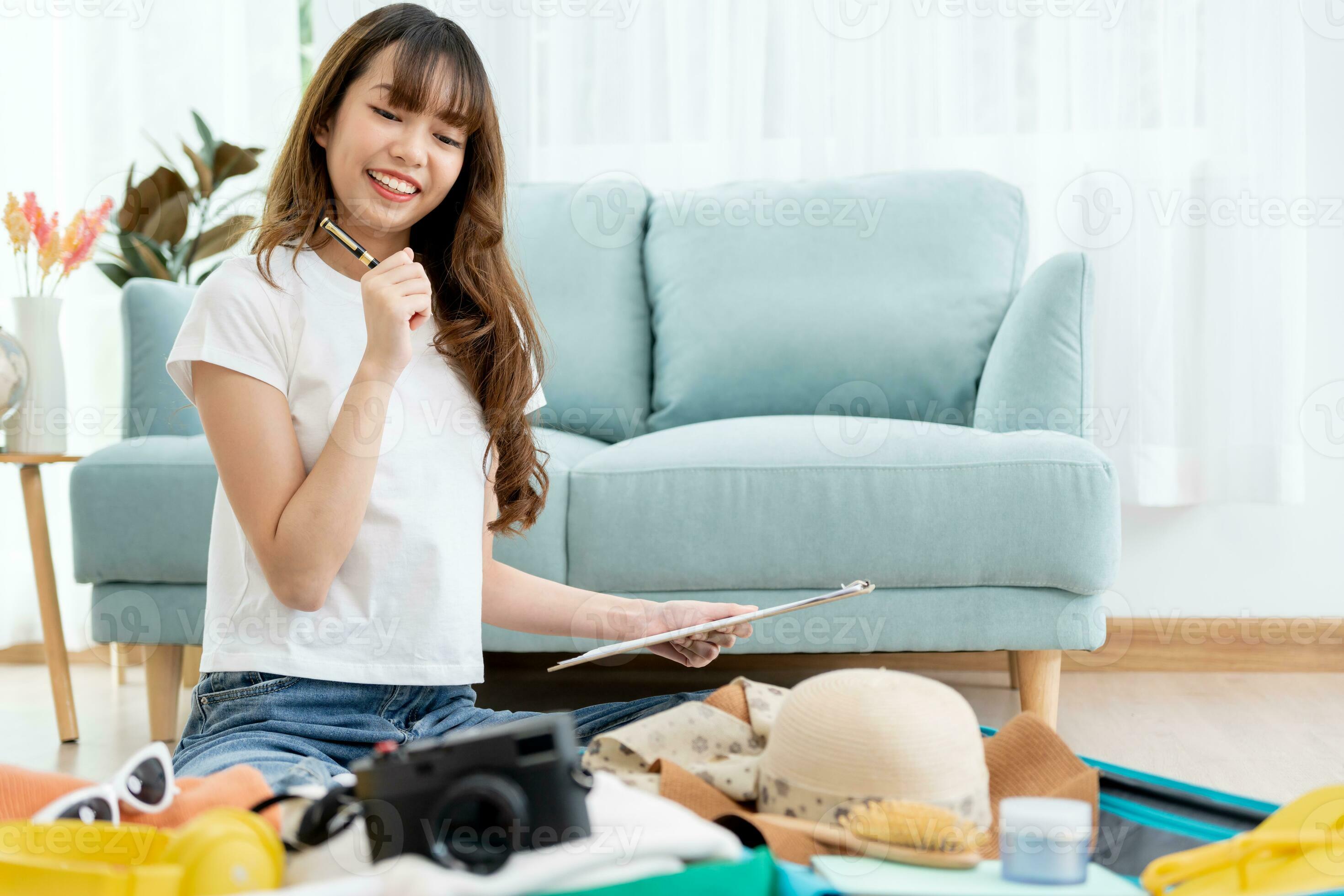 Travel bag. female are checking the detail and quantity of items used during the trip by ...