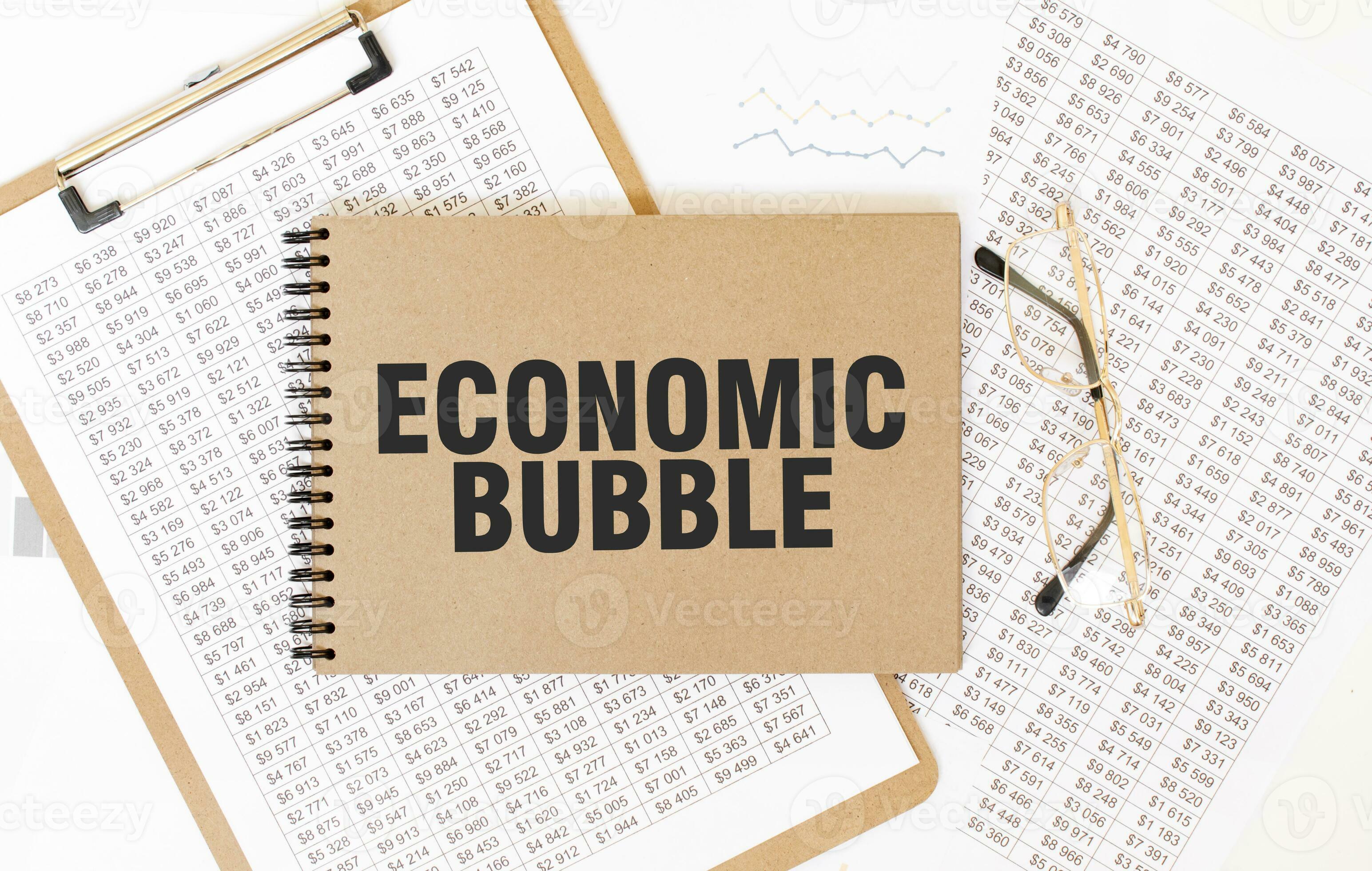 Craft colour notepad with text ECONOMIC BUBBLE. Notepad with eyeglasses and text documents ...