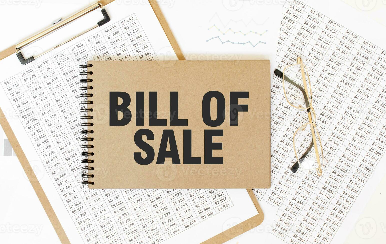 Craft colour notepad with text BILL OF SALE. Notepad with eyeglasses and text documents ...