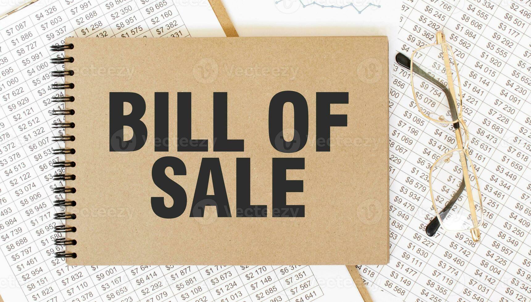 Craft colour notepad with text BILL OF SALE. Notepad with eyeglasses and text documents ...