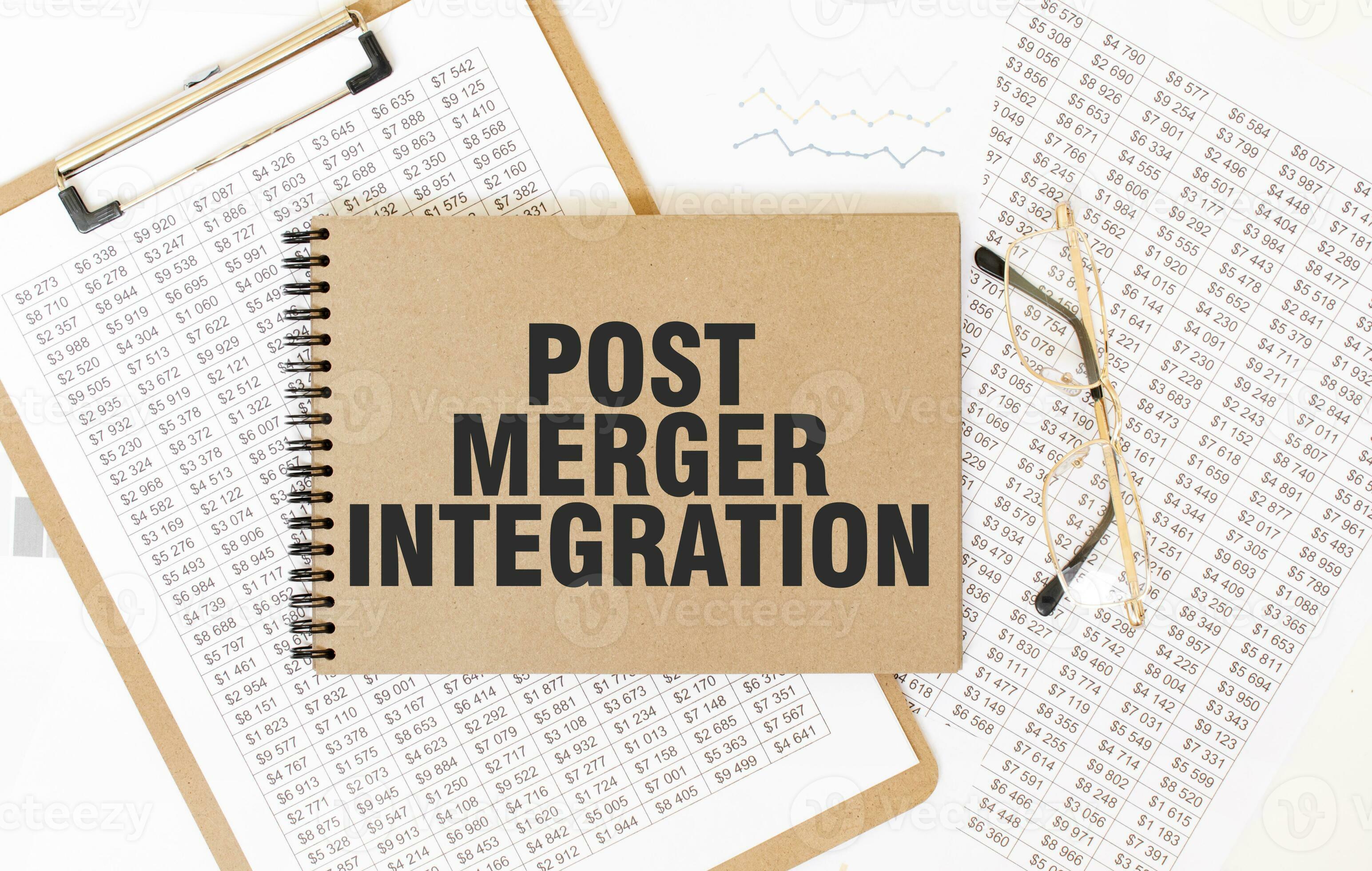 Craft colour notepad with text POST MERGER INTEGRATION. Notepad with eyeglasses and text ...