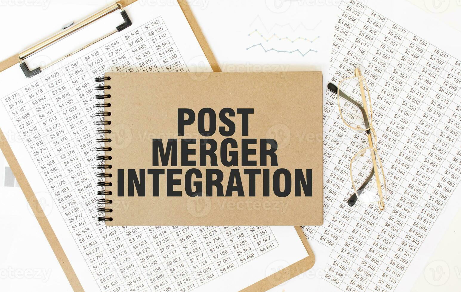 Craft colour notepad with text POST MERGER INTEGRATION. Notepad with eyeglasses and text ...