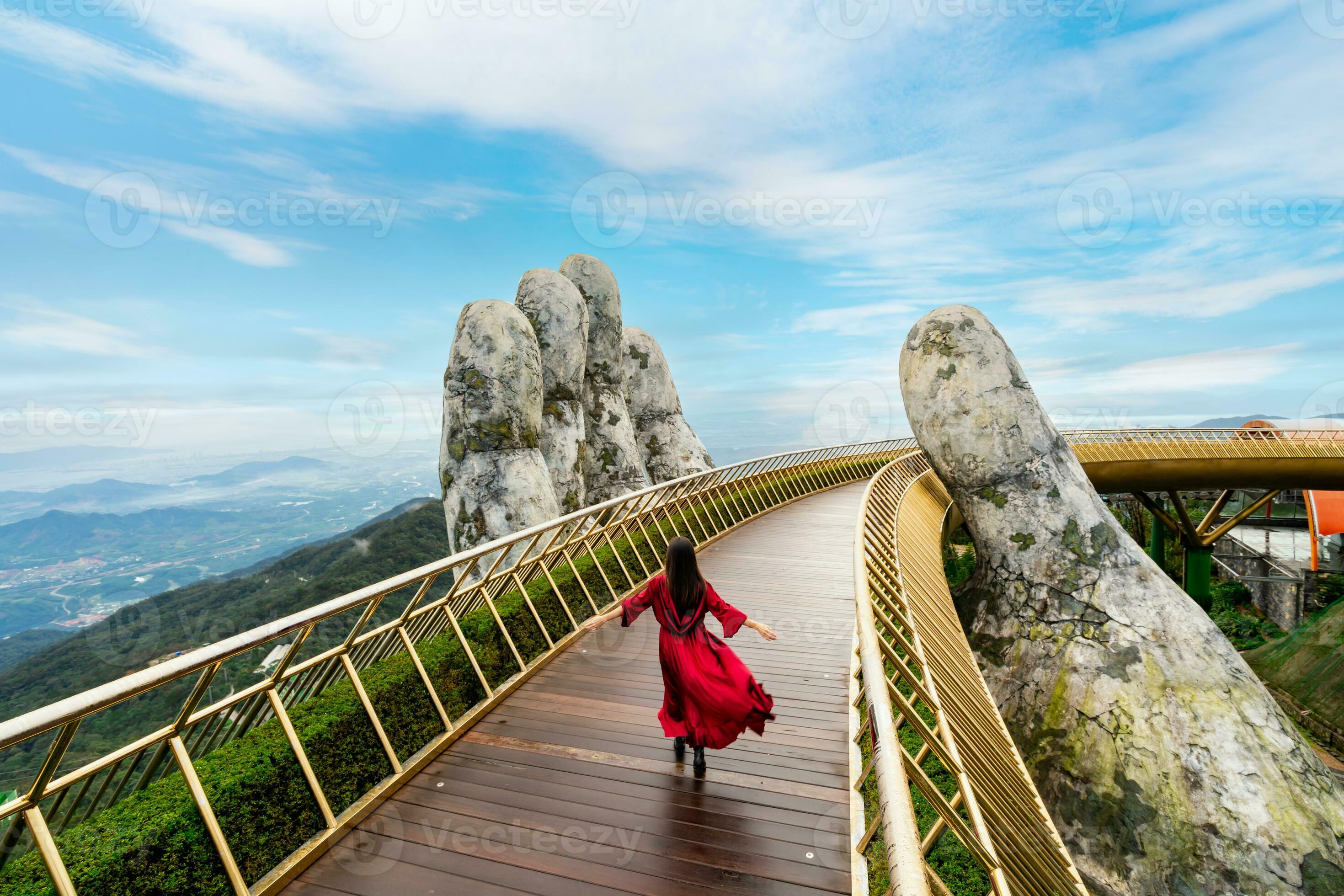 Young woman traveler in red dress enjoying at Golden Bridge in Bana hills, Danang Vietnam ...